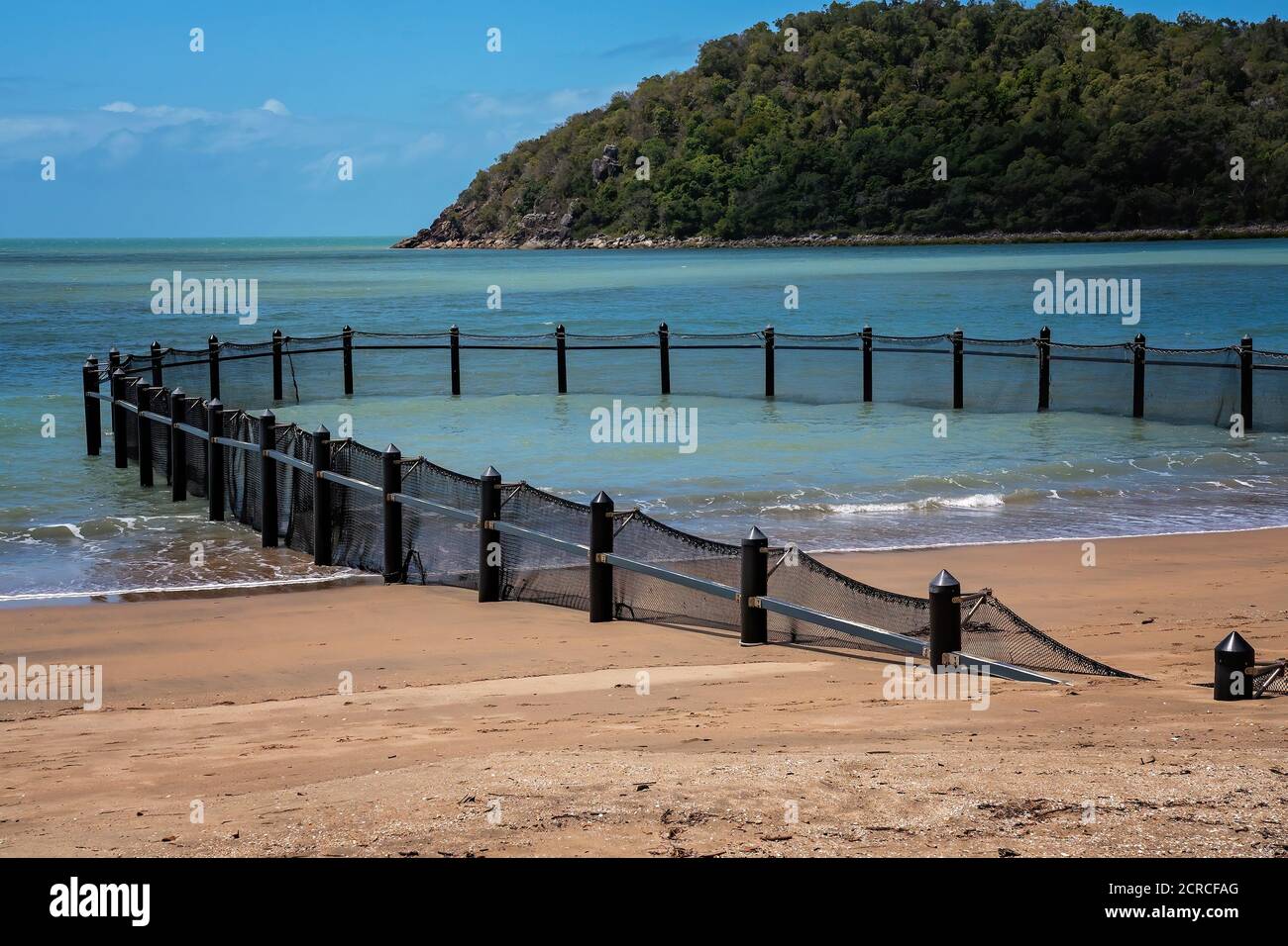 A netted swimming enclosure on a beach to protect swimmers from ...