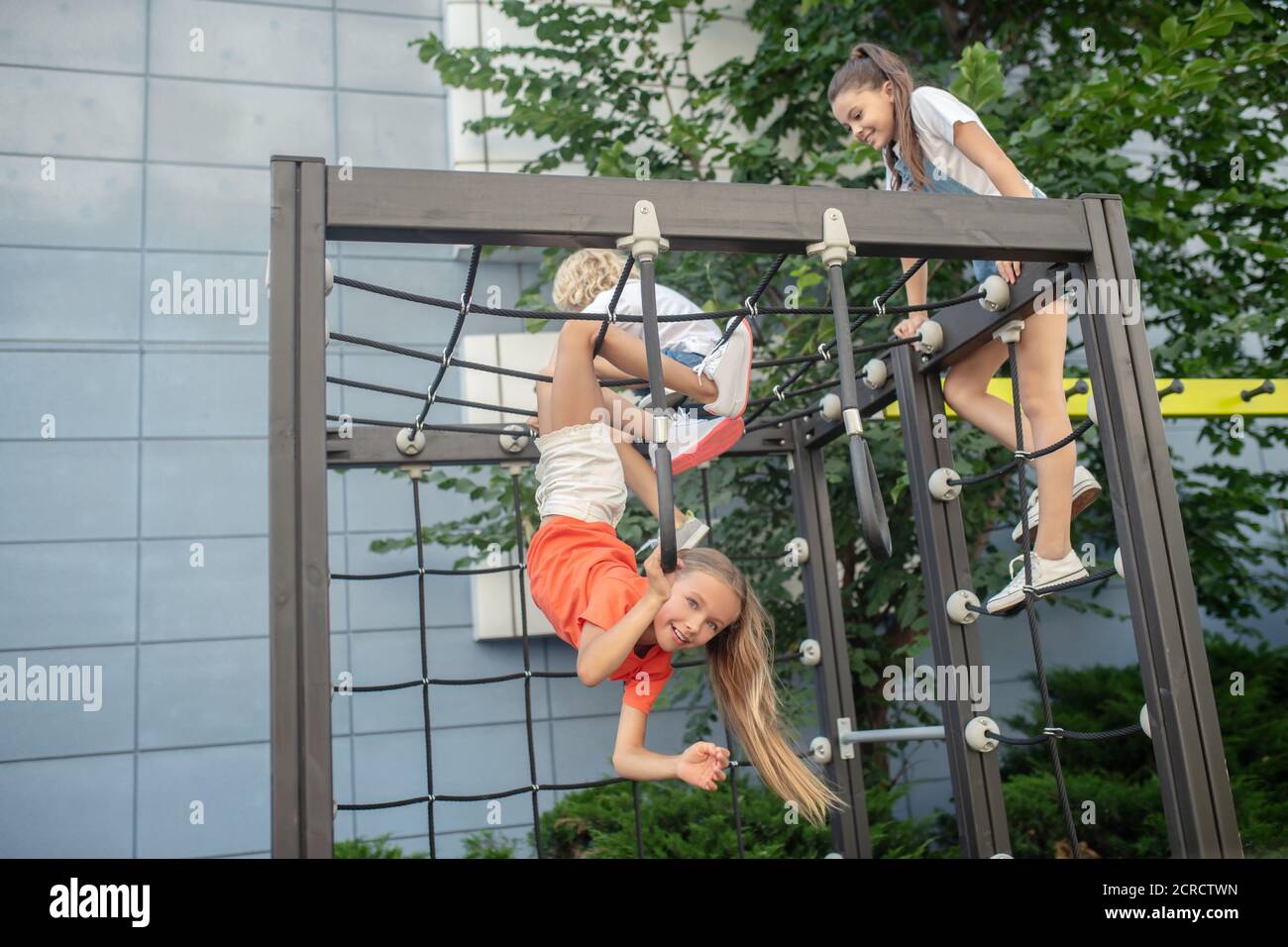 Kids climbing on outdoor playground and looking excited Stock Photo - Alamy