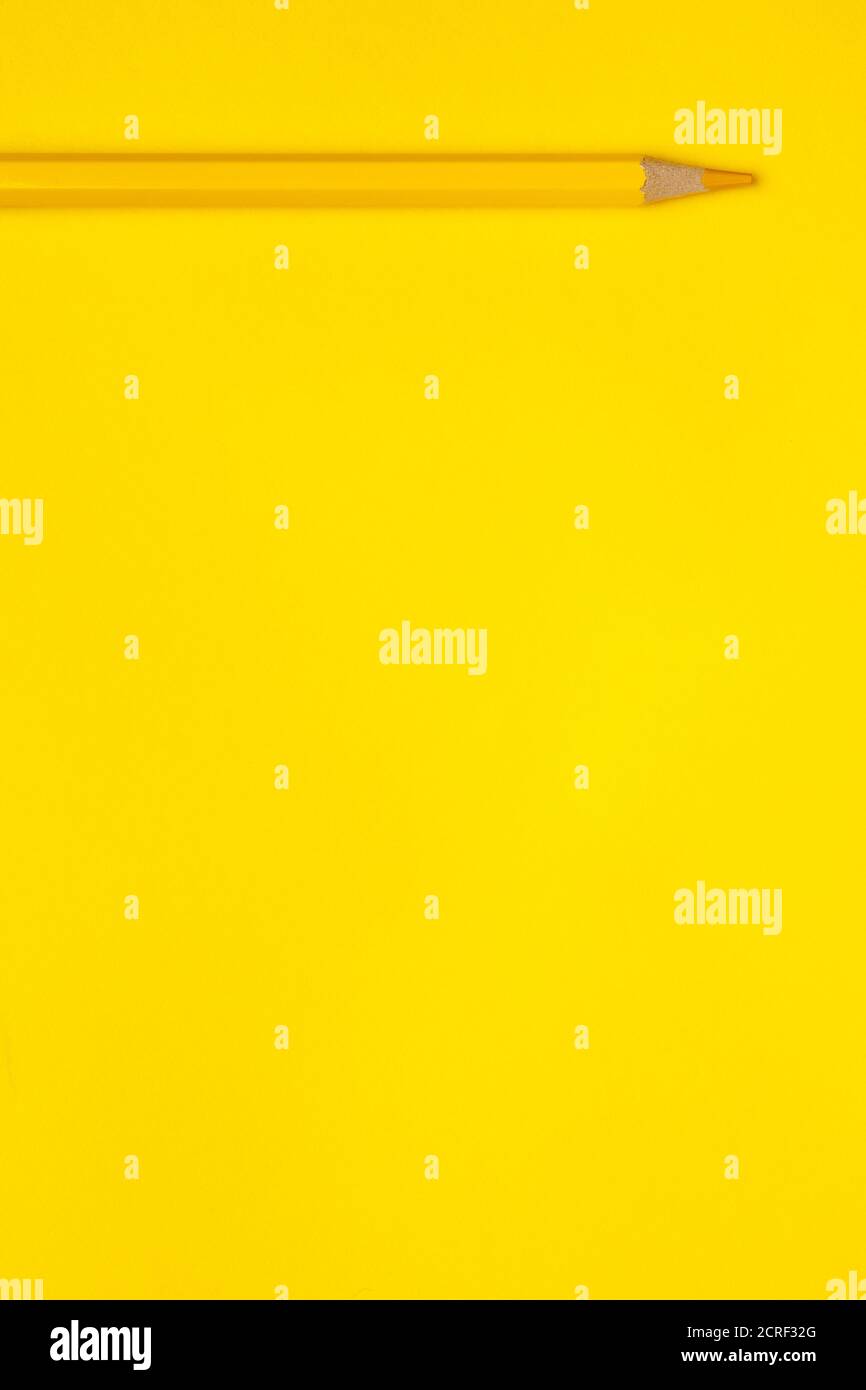 horizontal yellow sharp wooden pencil on a bright yellow background ...