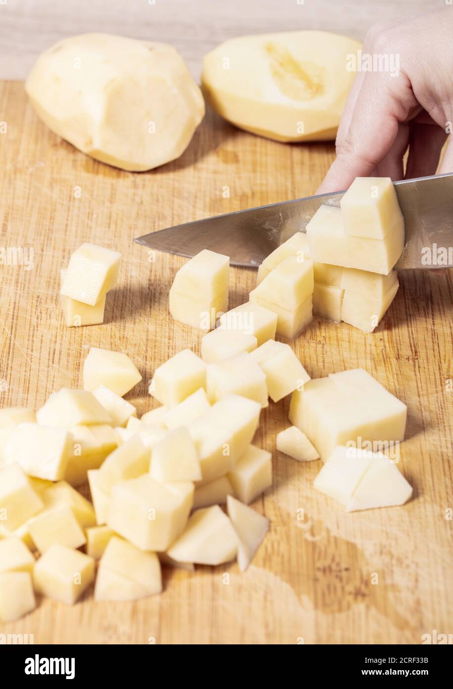 Woman cuts potatoes on cutting hi-res stock photography and images - Alamy