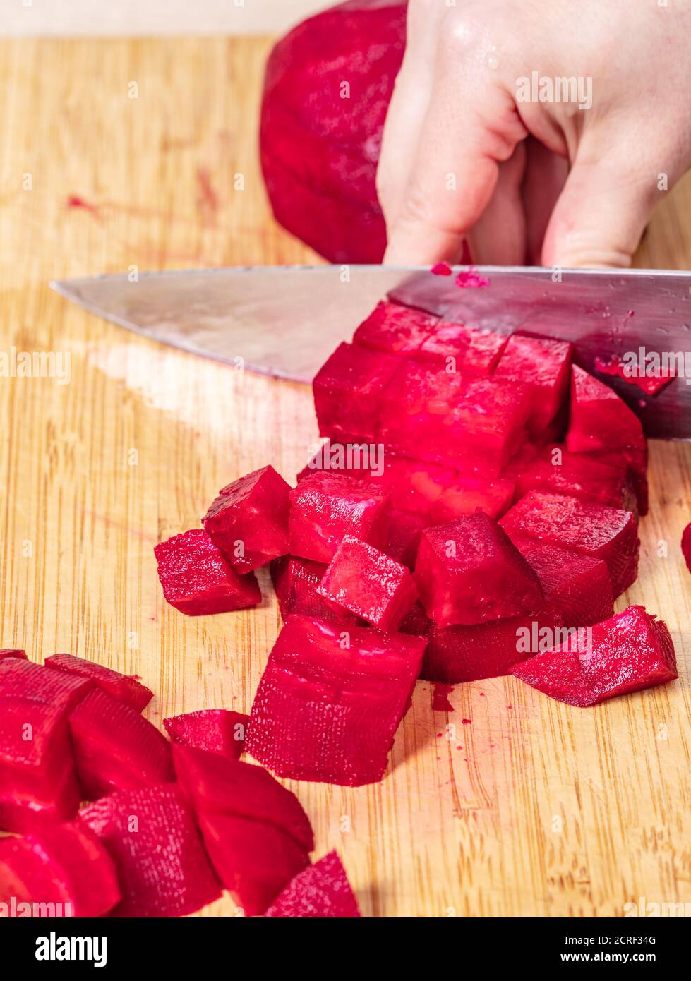 cook cuts red beet on a wooden board, preparation for cooking Stock ...
