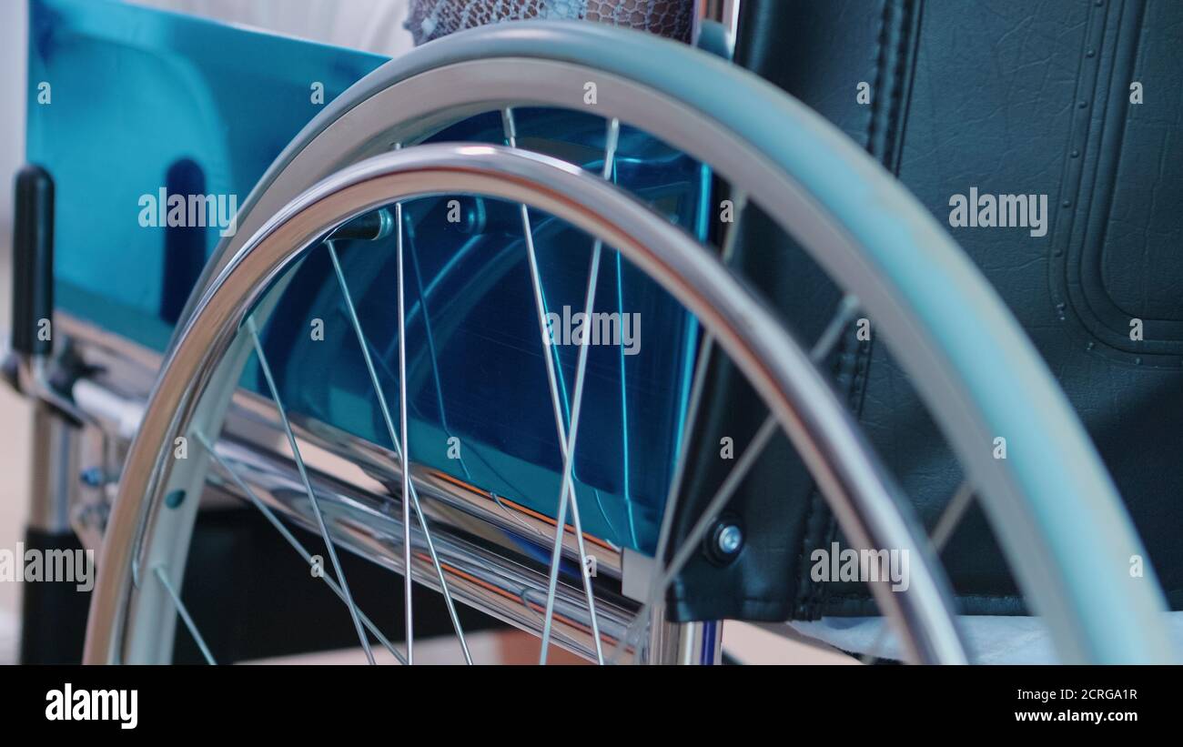 Close up of rolling wheelchair with disabled patient in hospital ...
