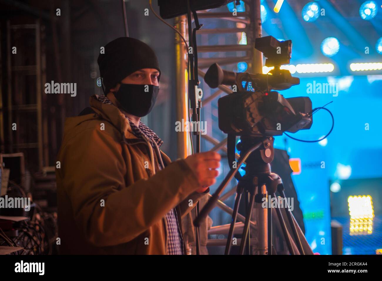 masked cameraman is filming a television show in the studio. TV Stock ...