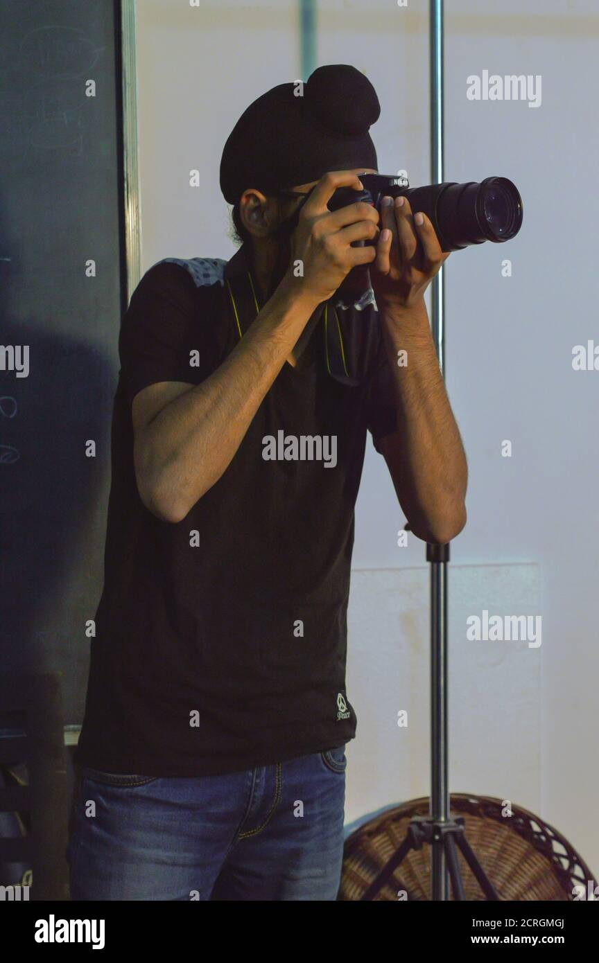 A student using nikon camera at classroom taking portrait of others ...