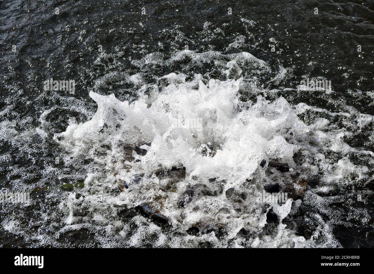 Spring, a stream of water hits through the water surface Stock Photo ...