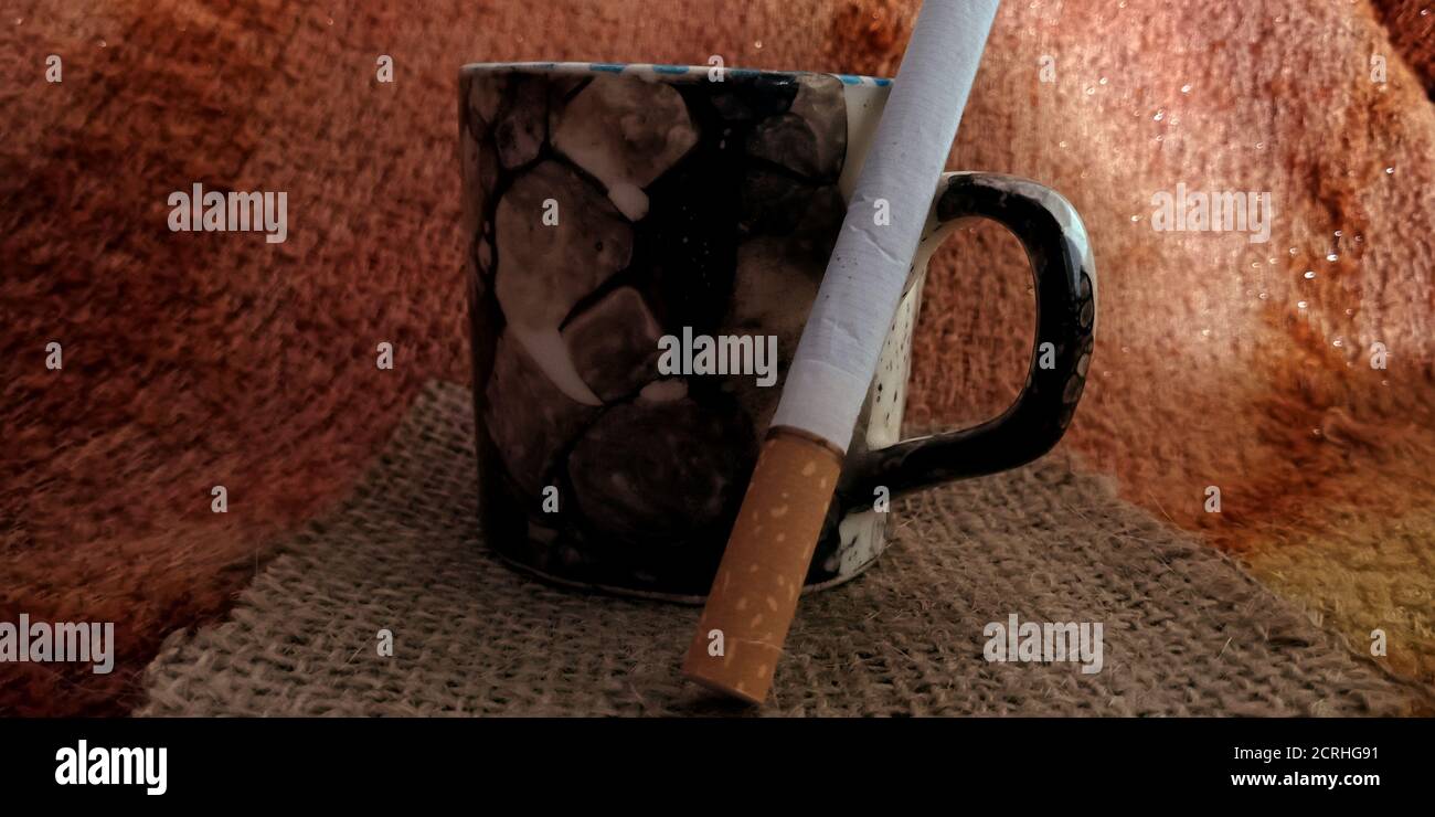 Tea cup with cigarette on brown sack mat background, pack of cigarettes ...