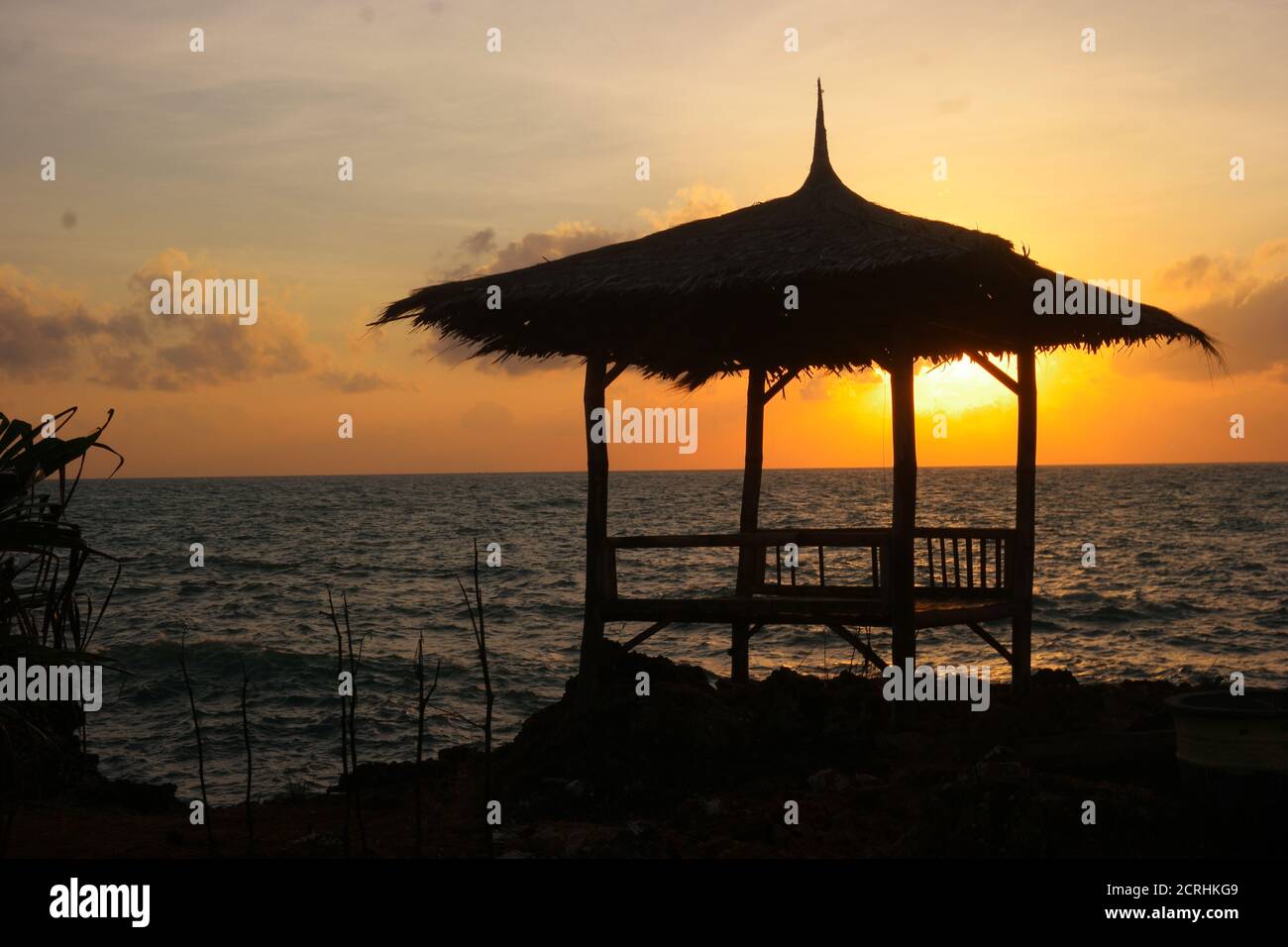 View of a small hut near the ocean during sunset Stock Photo - Alamy