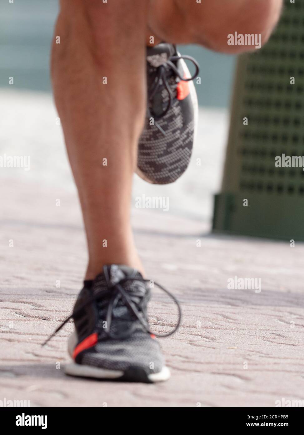 Legs of sporty middle age man training. Regular run in outdoors in park ...