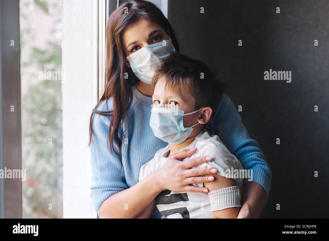 Quarantined family isolated at home. Mother and her son in protective ...