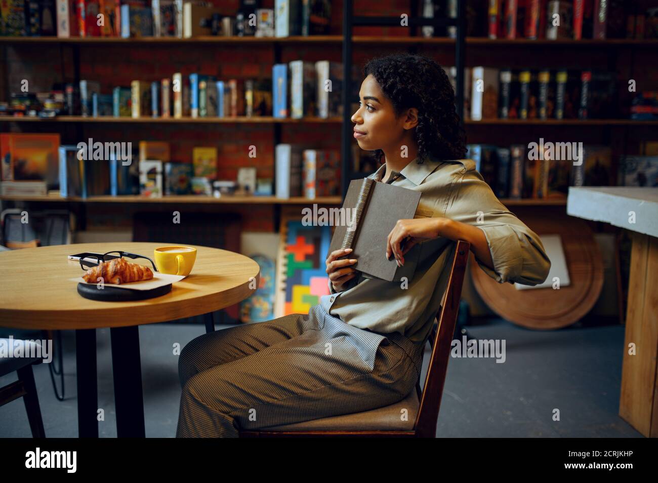 Female student reads book in library cafe Stock Photo - Alamy