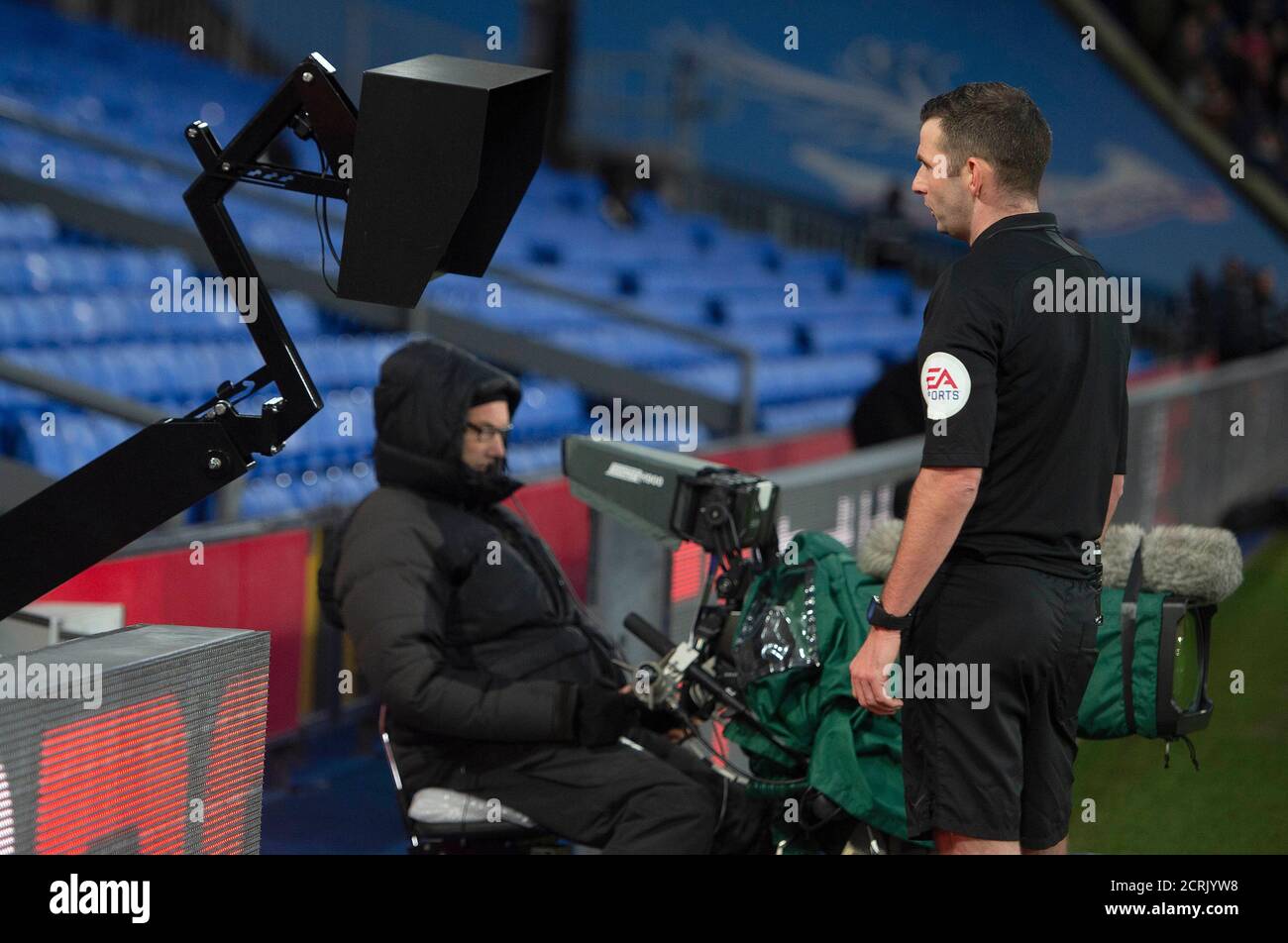 Referee Michael Oliver views the pitch-side VAR screen and then sends ...