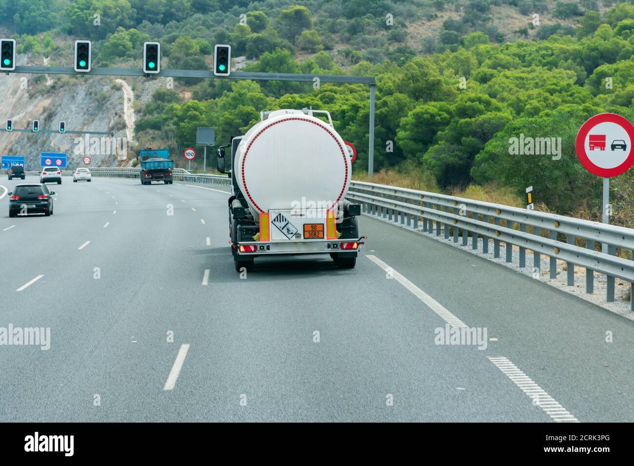 Dangerous goods tank truck driving on a multi-lane highway with traffic ...