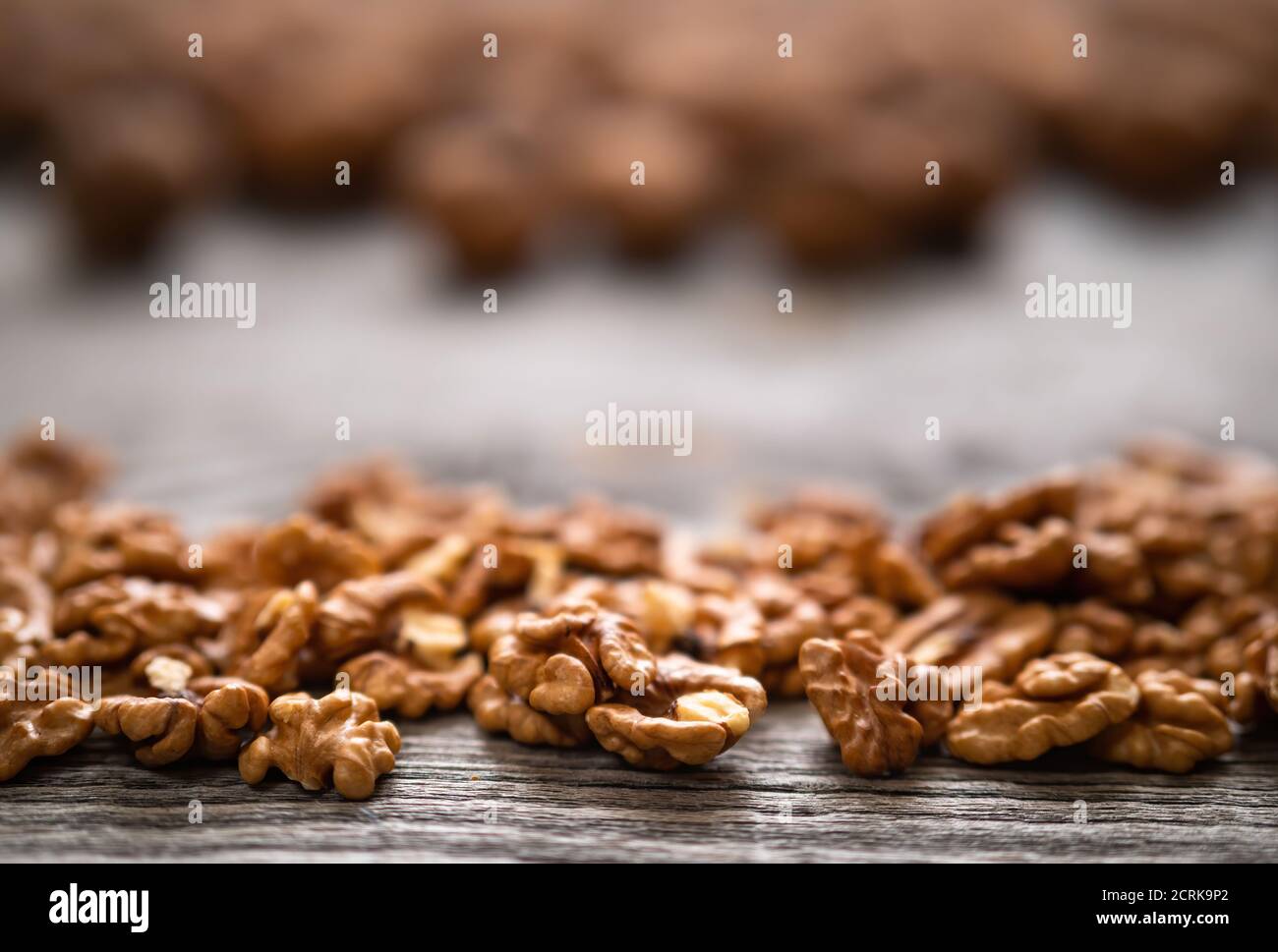 Heap of fresh walnut kernels and whole walnuts on wooden table ...