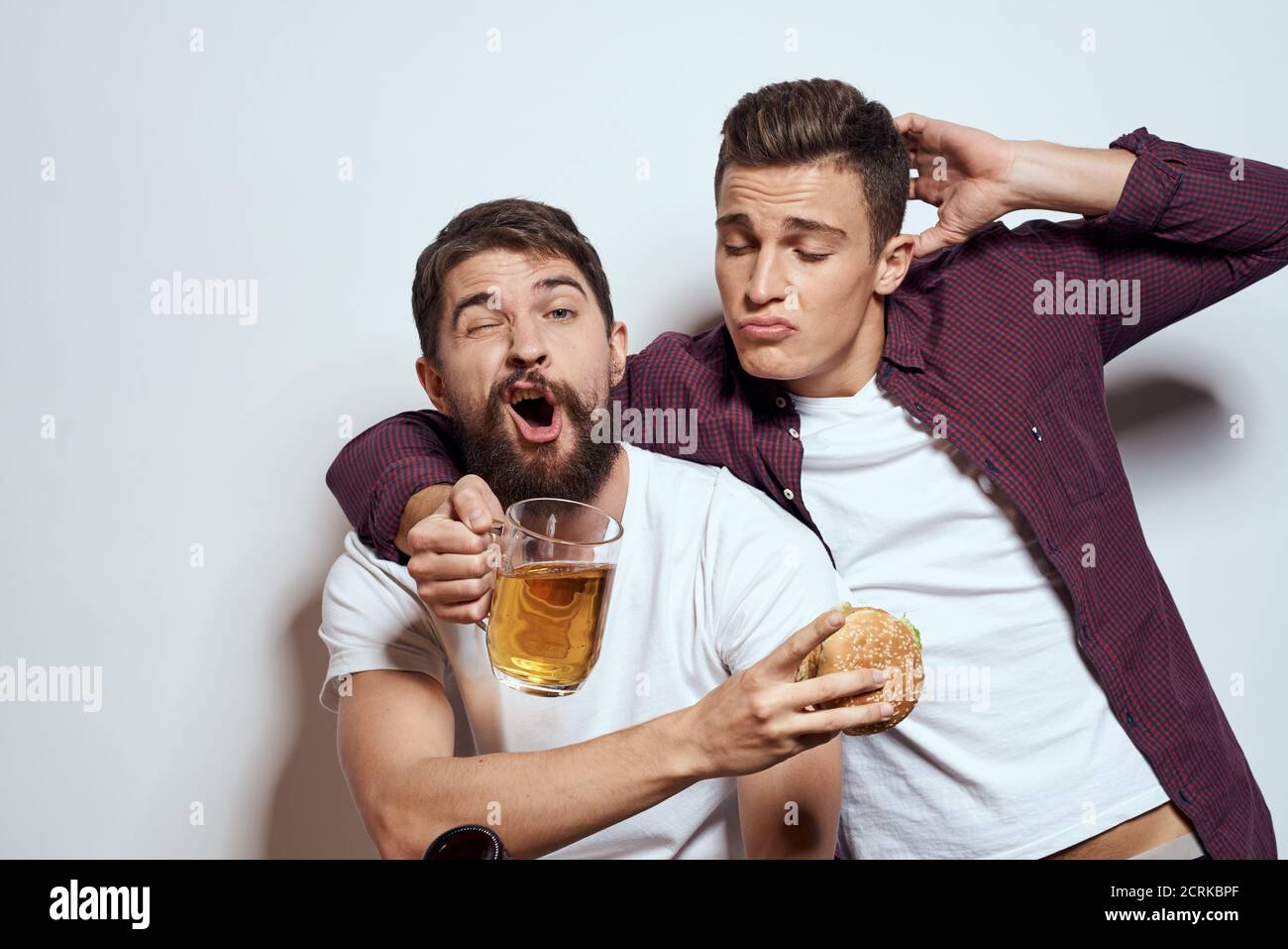 Two cheerful friends drinking beer drunk fun lifestyle communication ...