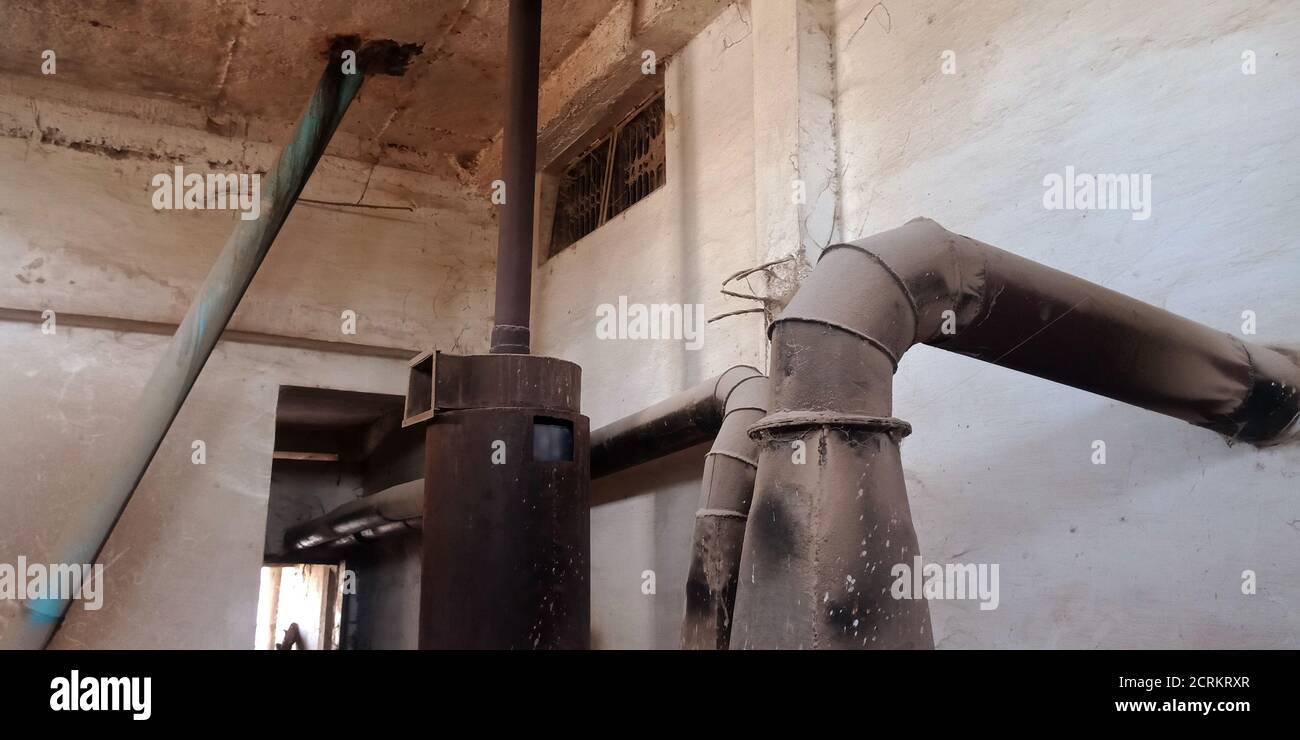 an old rusty rice mill machinery tool exposed to the dusty background ...