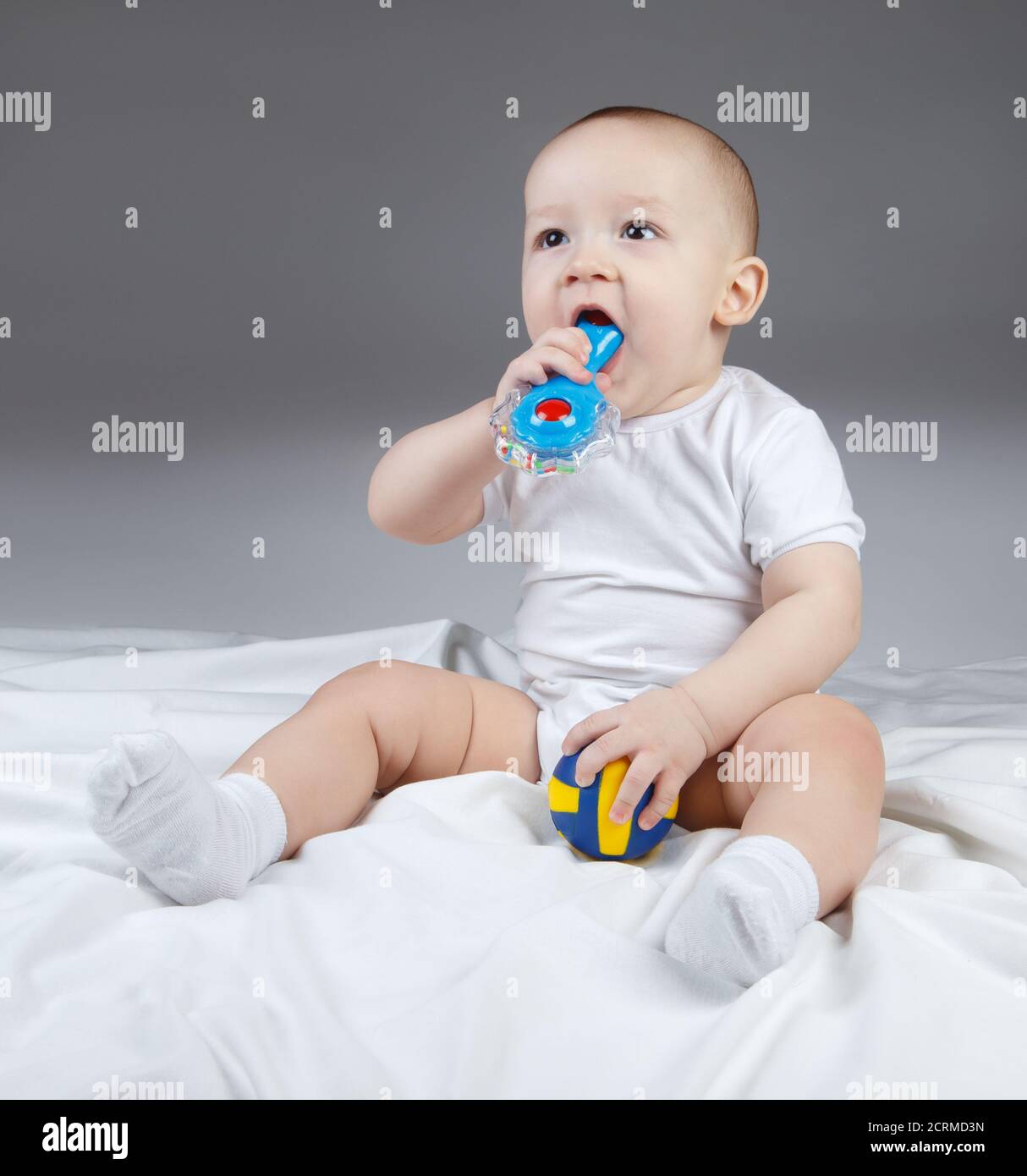 Image of a ten-month-old baby with rattle and ball Stock Photo - Alamy