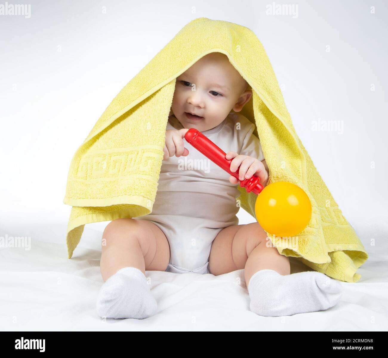 Photo of a eleven-month-old baby with rattle and towel Stock Photo - Alamy