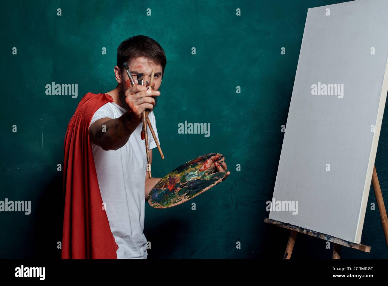 Male artist red cloak drawing easel art green background image Stock ...