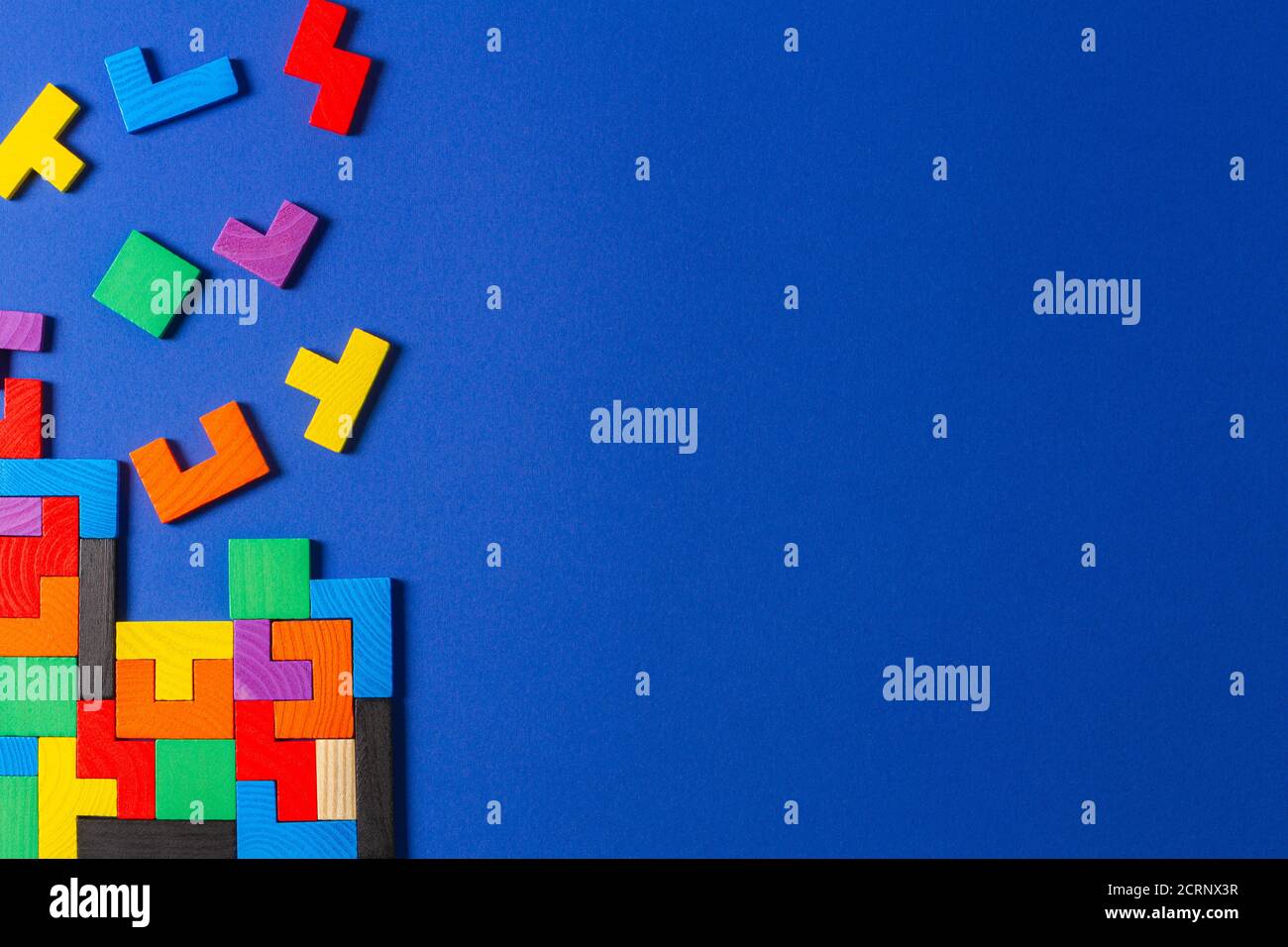 Different colorful shapes wooden puzzle blocks on blue background ...