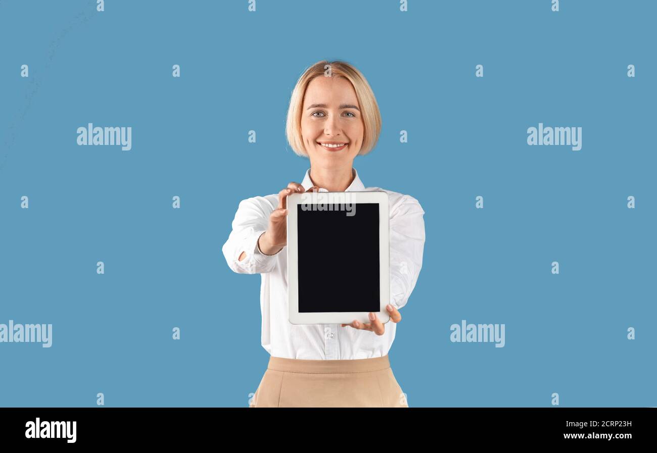 Happy business lady presenting tablet computer with blank screen for ...