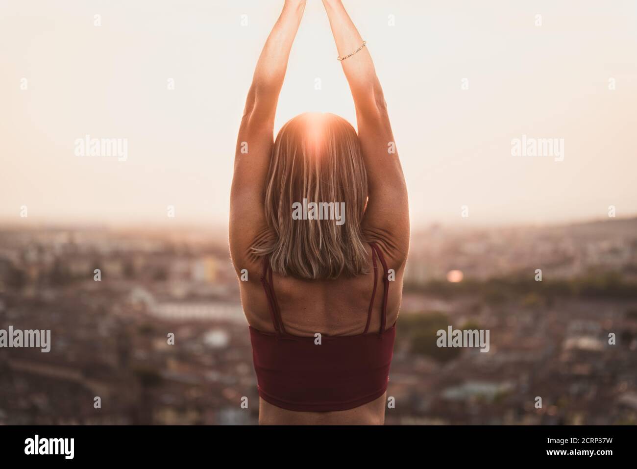 Front view of a back light of a faithful woman in yoga position holding ...