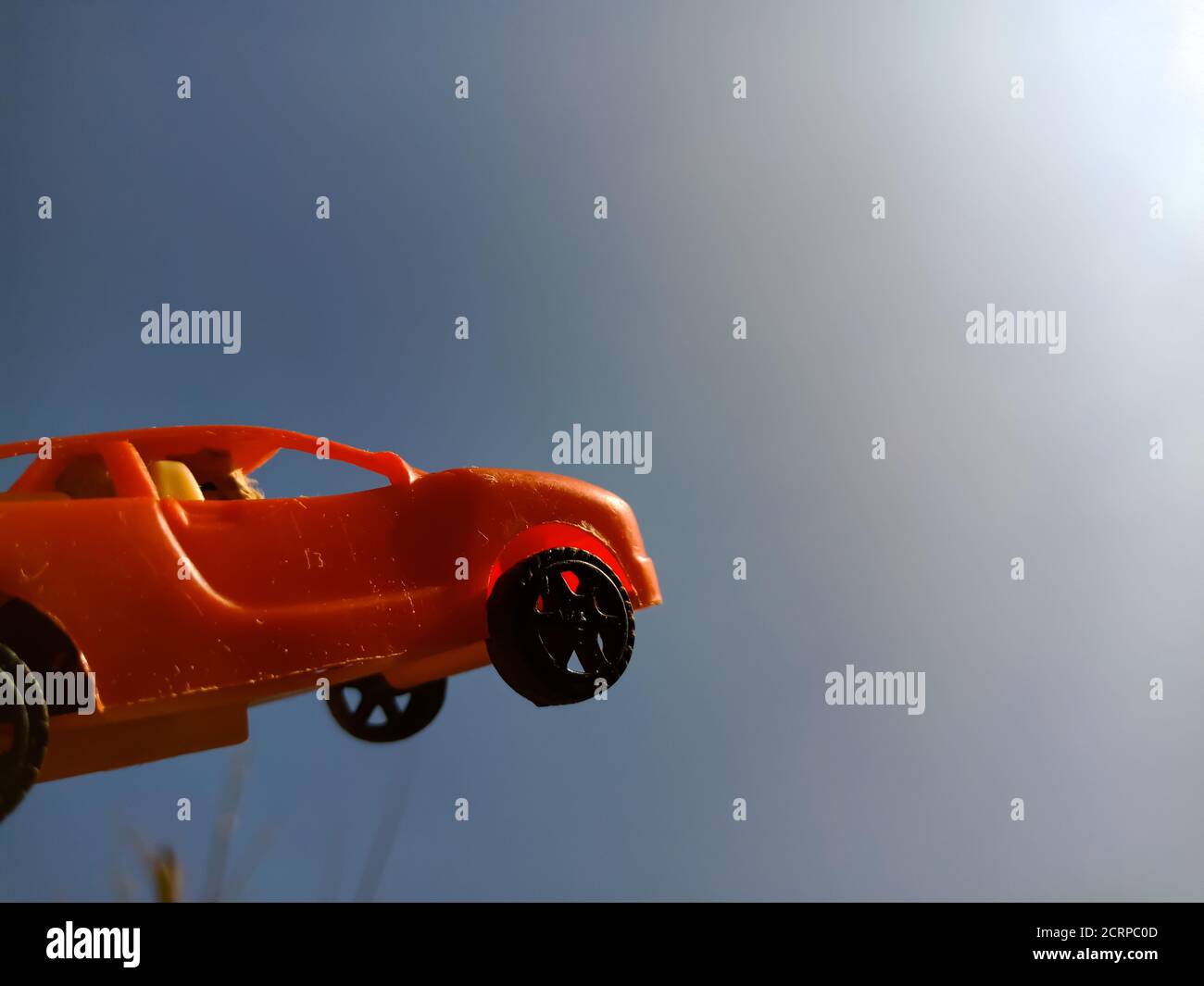 Red Color toy car isolated on blue sky background Stock Photo - Alamy