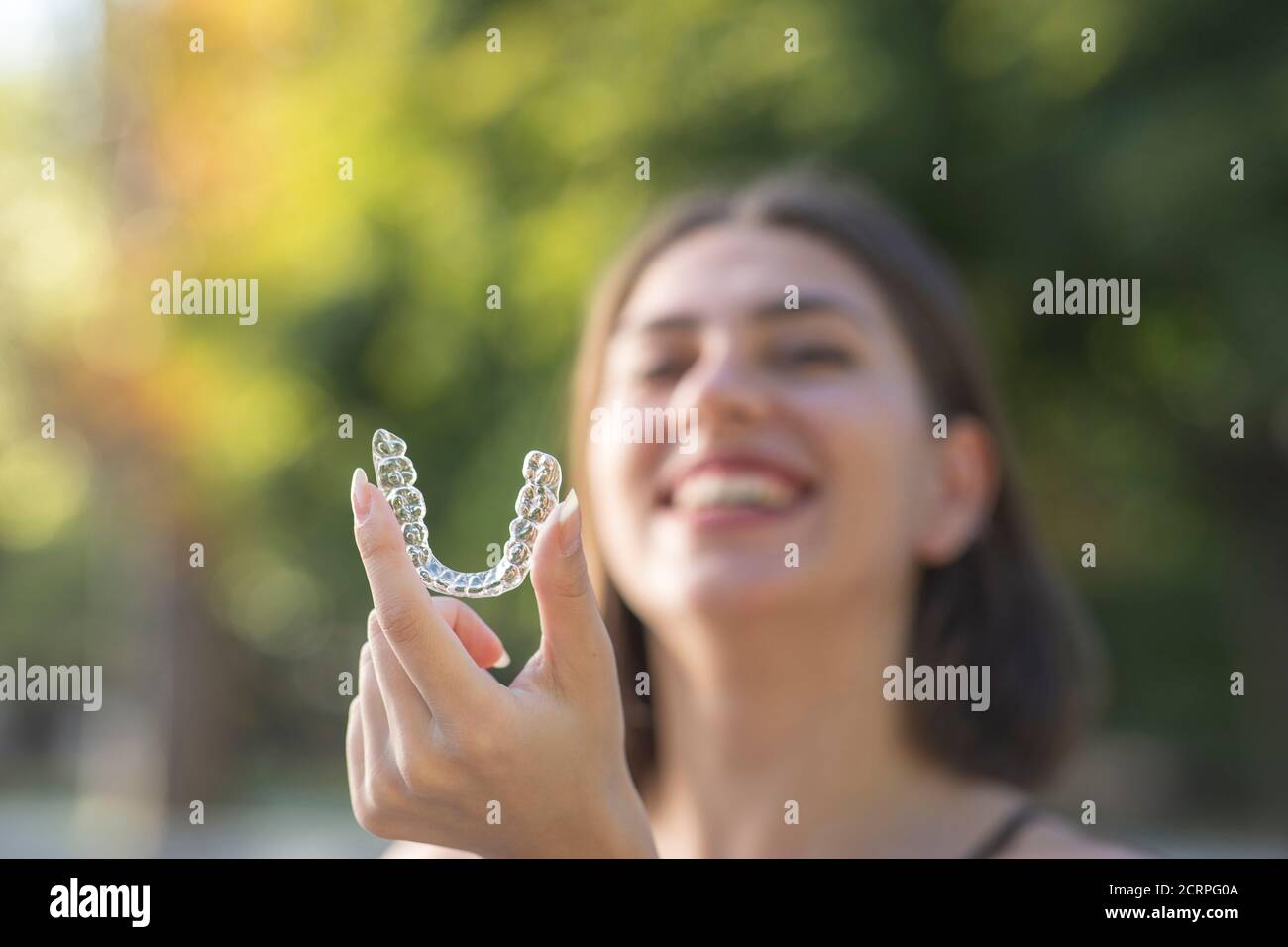 Beautiful smiling Turkish woman is holding an invisalign bracer Stock ...