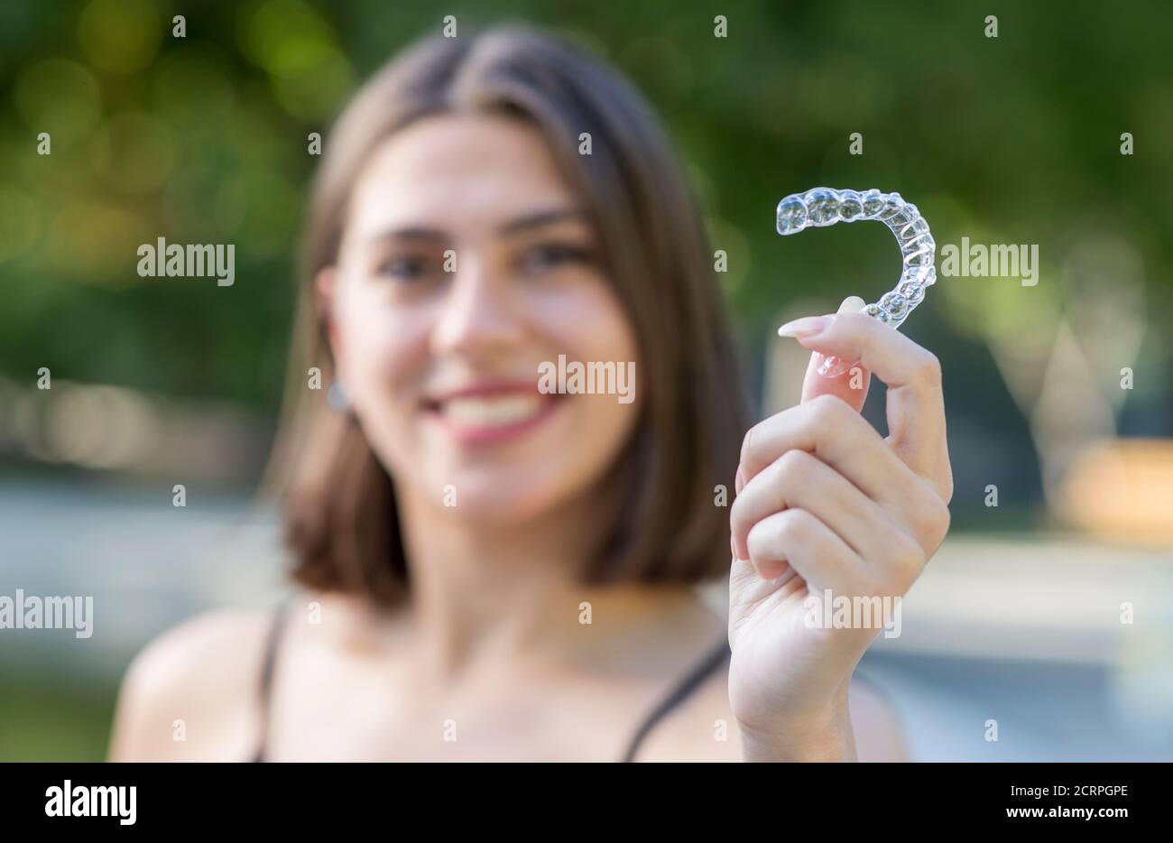 Beautiful smiling Turkish woman is holding an invisalign bracer Stock ...