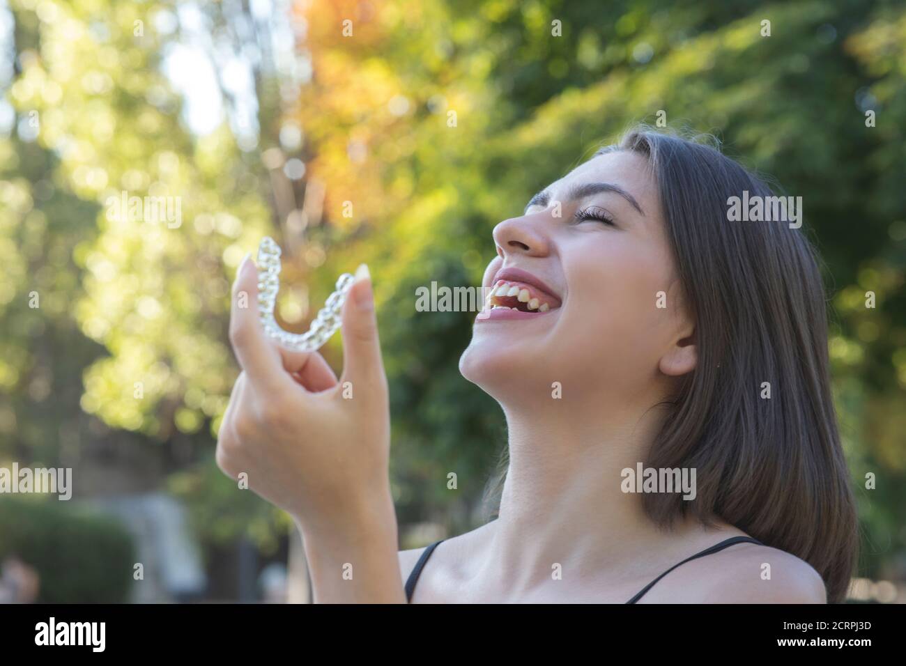 Beautiful smiling Turkish woman is holding an invisalign bracer Stock ...