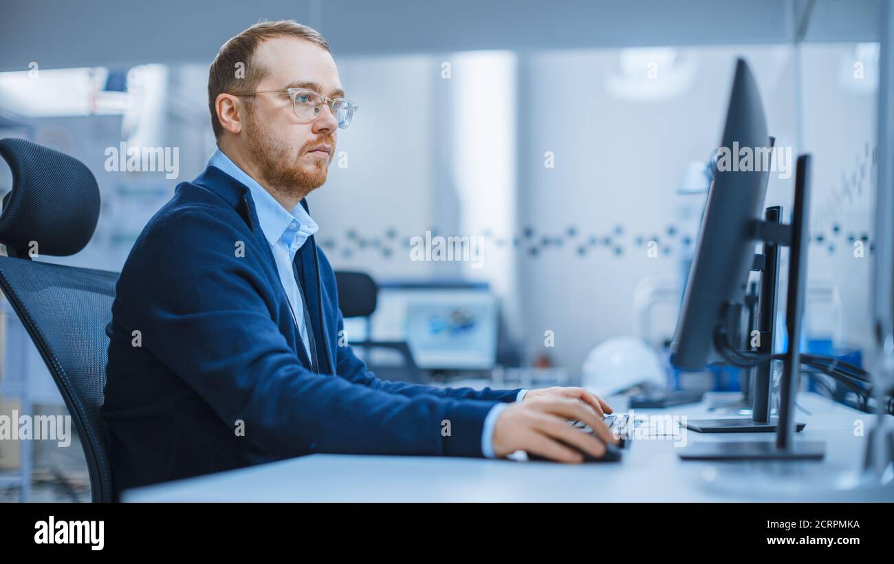 Shot of a Heavy Industry Engineer Working on Personal Computer in ...