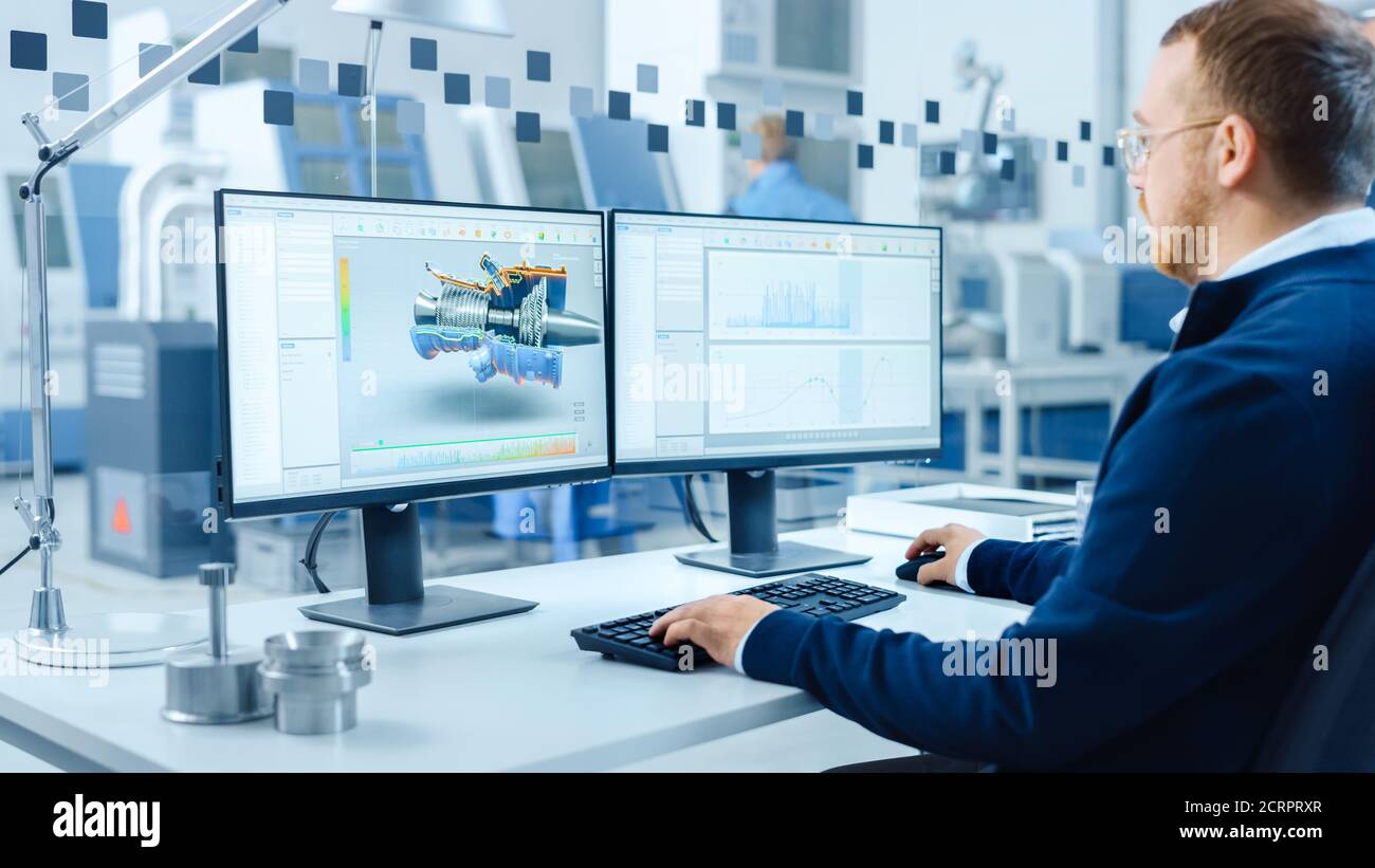 Industrial Engineer Working on a Personal Computer, Two Monitor Screens ...
