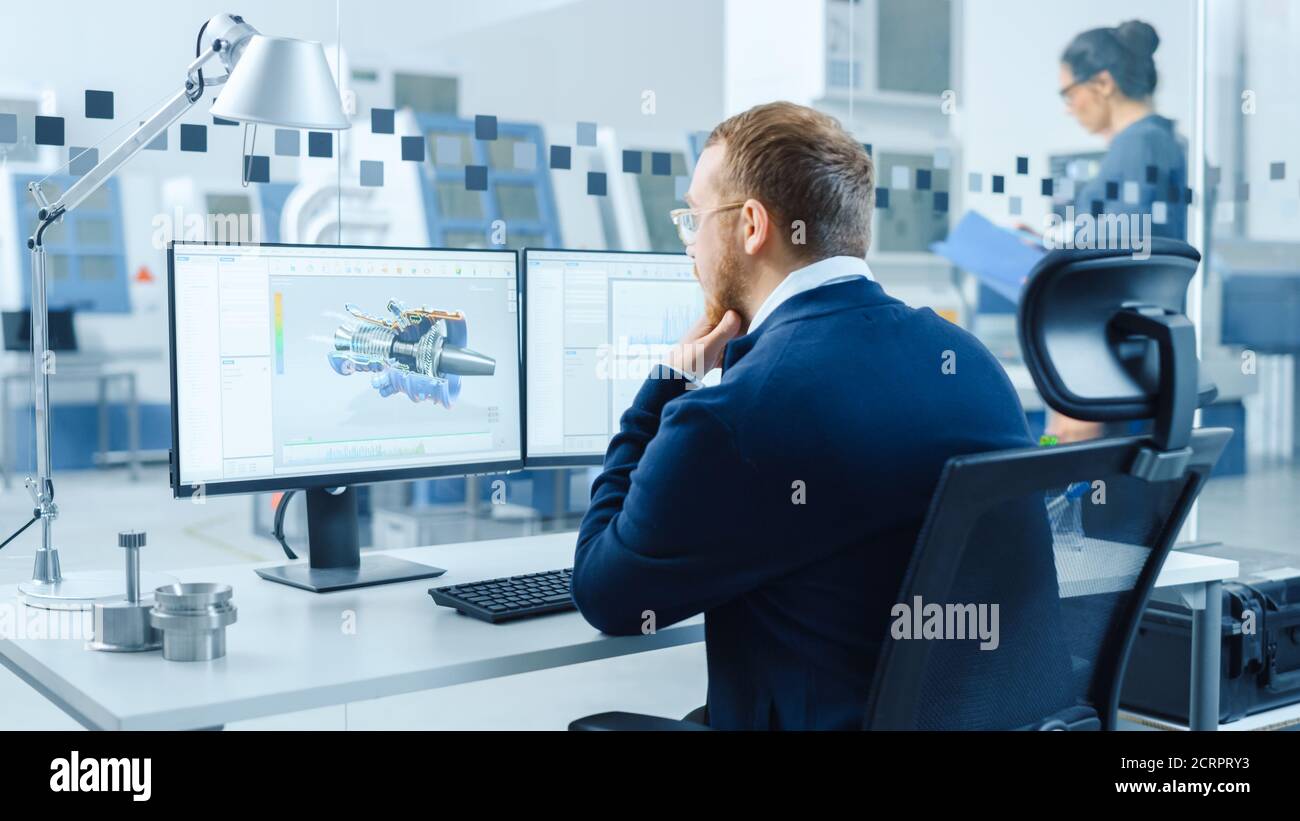 Industrial Engineer Working on a Personal Computer, Two Monitor Screens ...