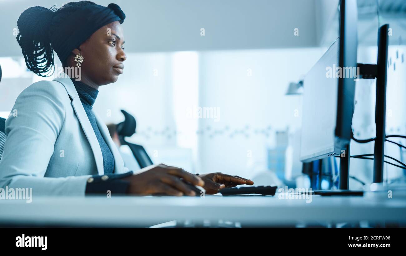 Beautiful Female Engineer Working on Personal Computer in the High-Tech ...