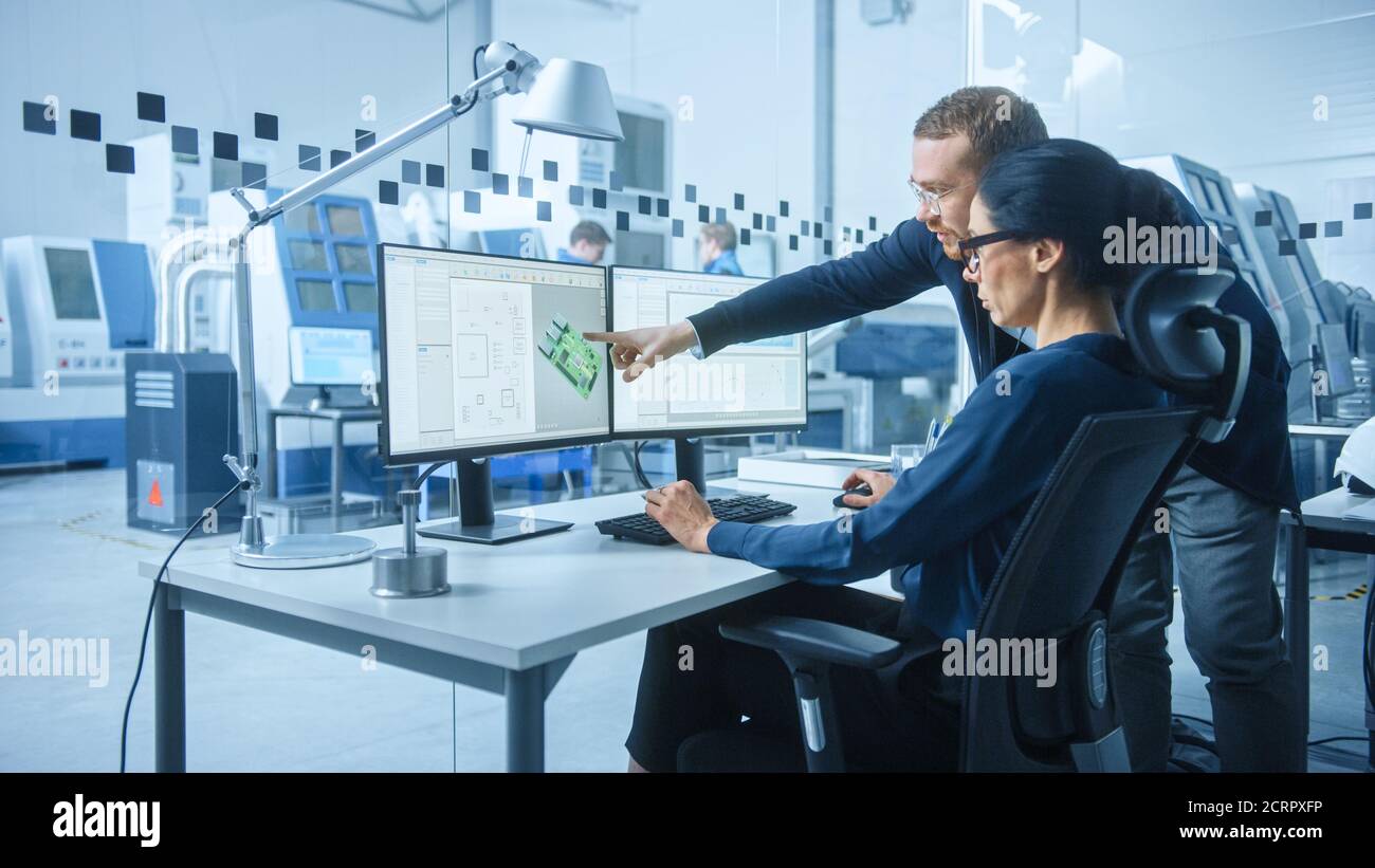 Modern Electronics Factory: Male Supervisor Talks to a Female ...