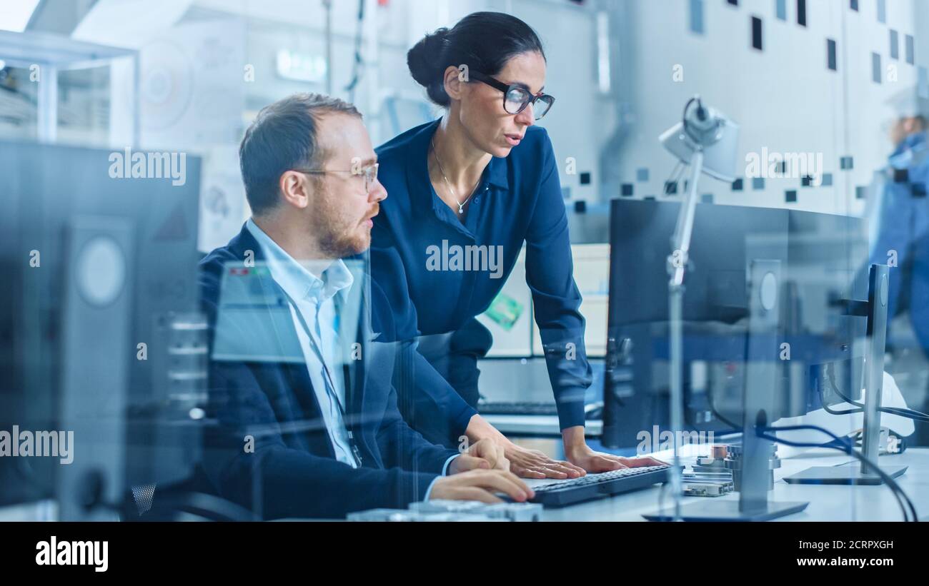 Modern Electronics Factory: Female Supervisor Talks to a Male ...