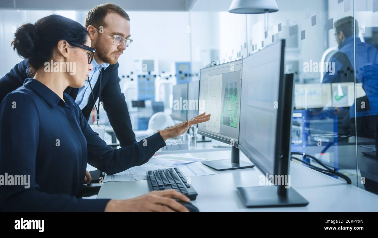 Modern Electronics Factory: Male Supervisor Talks to a Female ...