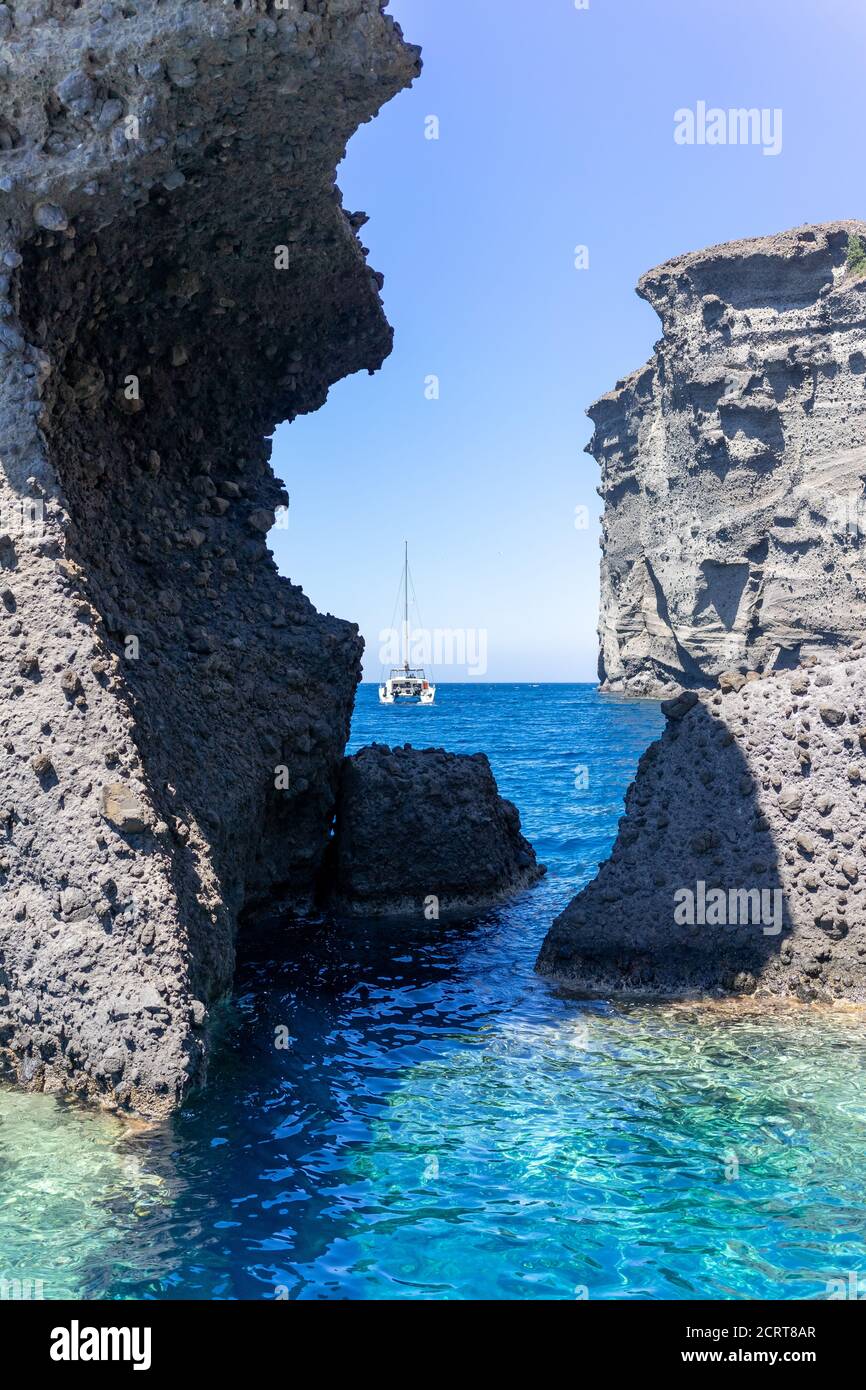 Catamaran on the blue sea in between rock formation. Akrotiri ...
