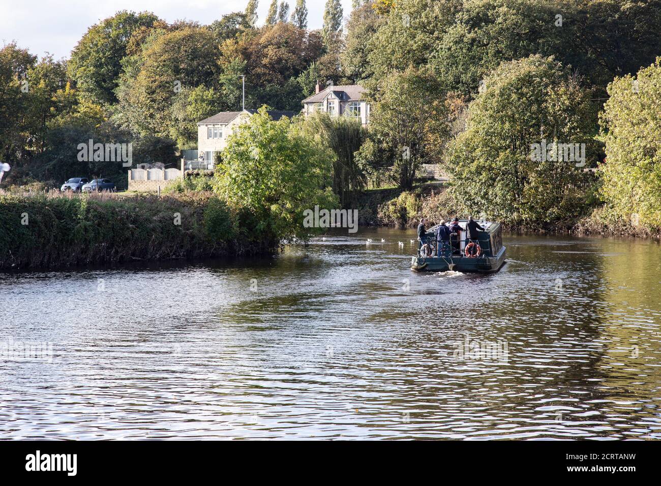 A Canal boat or barge with four men at the stern on the Calder and ...
