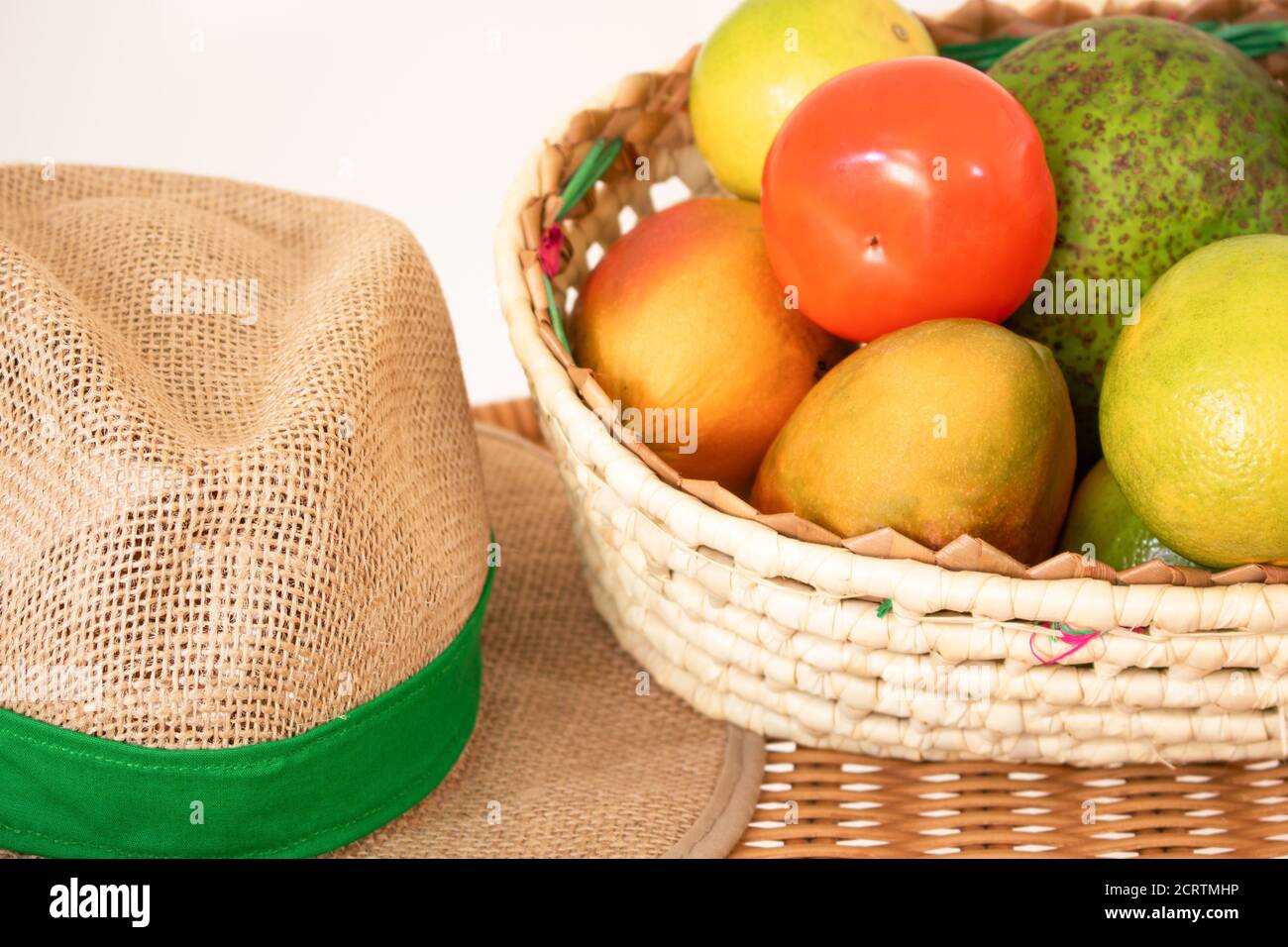 Basket of vegetables and straw hat on the table. Agriculture concept ...