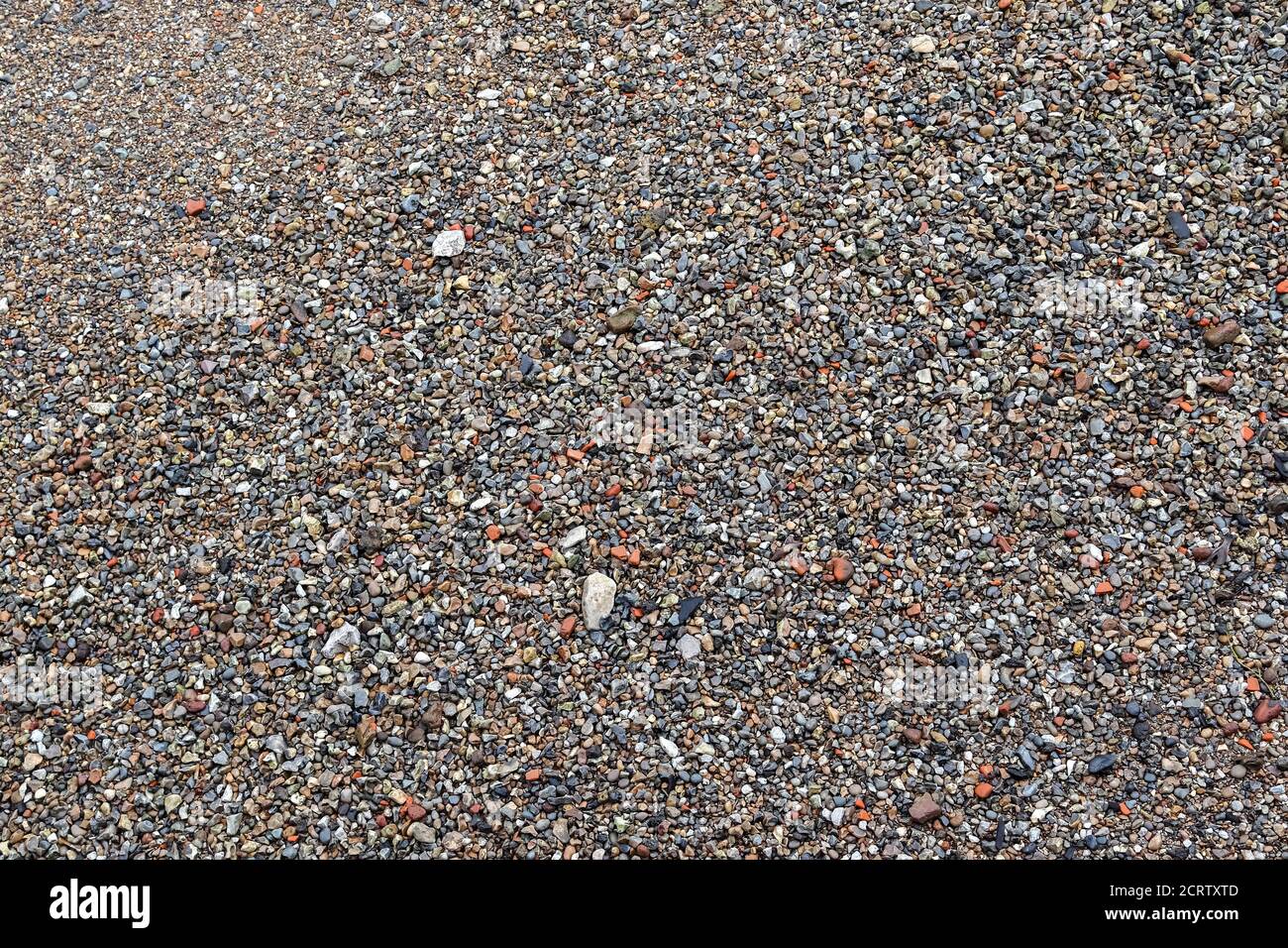 Detailed close up view on pebbles and stones on a gravel ground texture ...