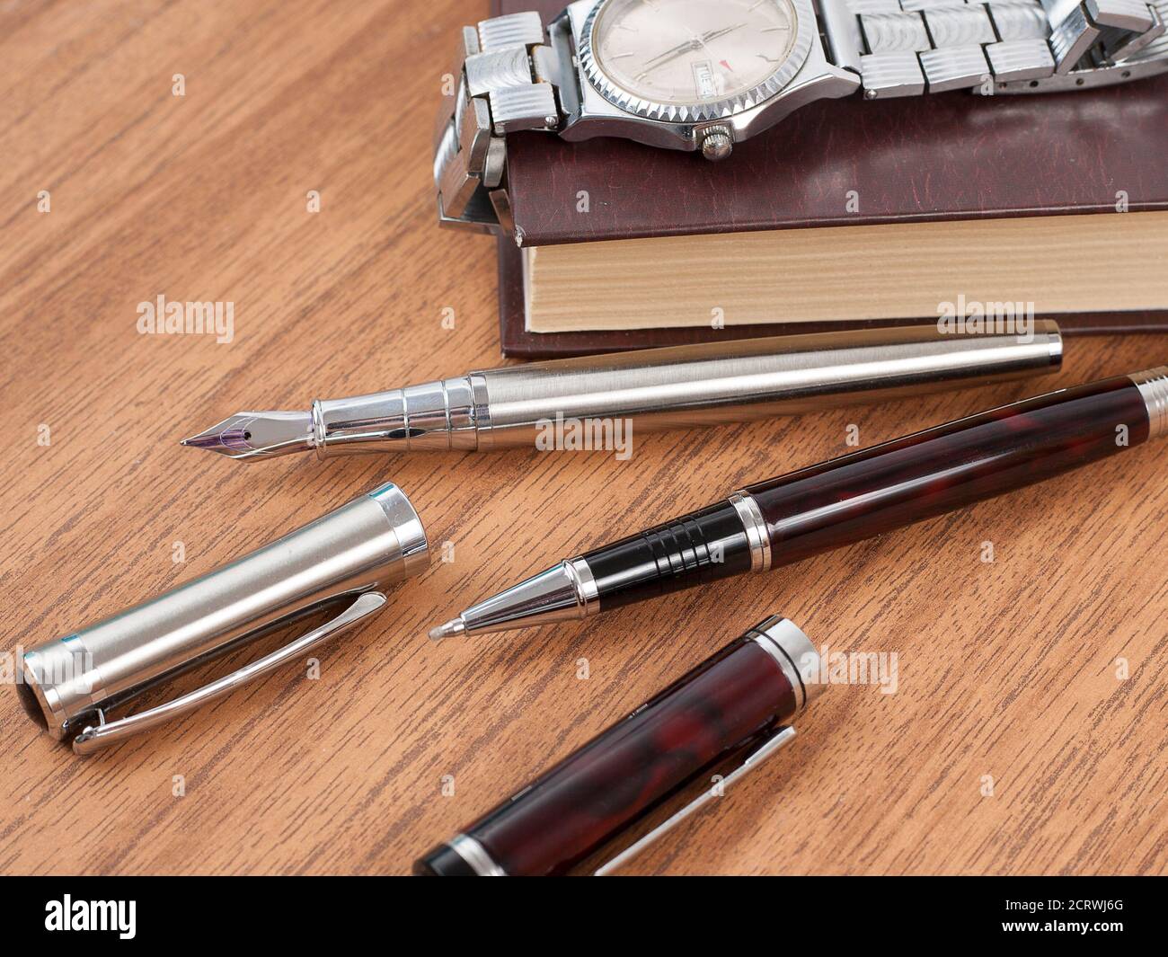 Notepad, pen and watches on the wood desk Stock Photo - Alamy