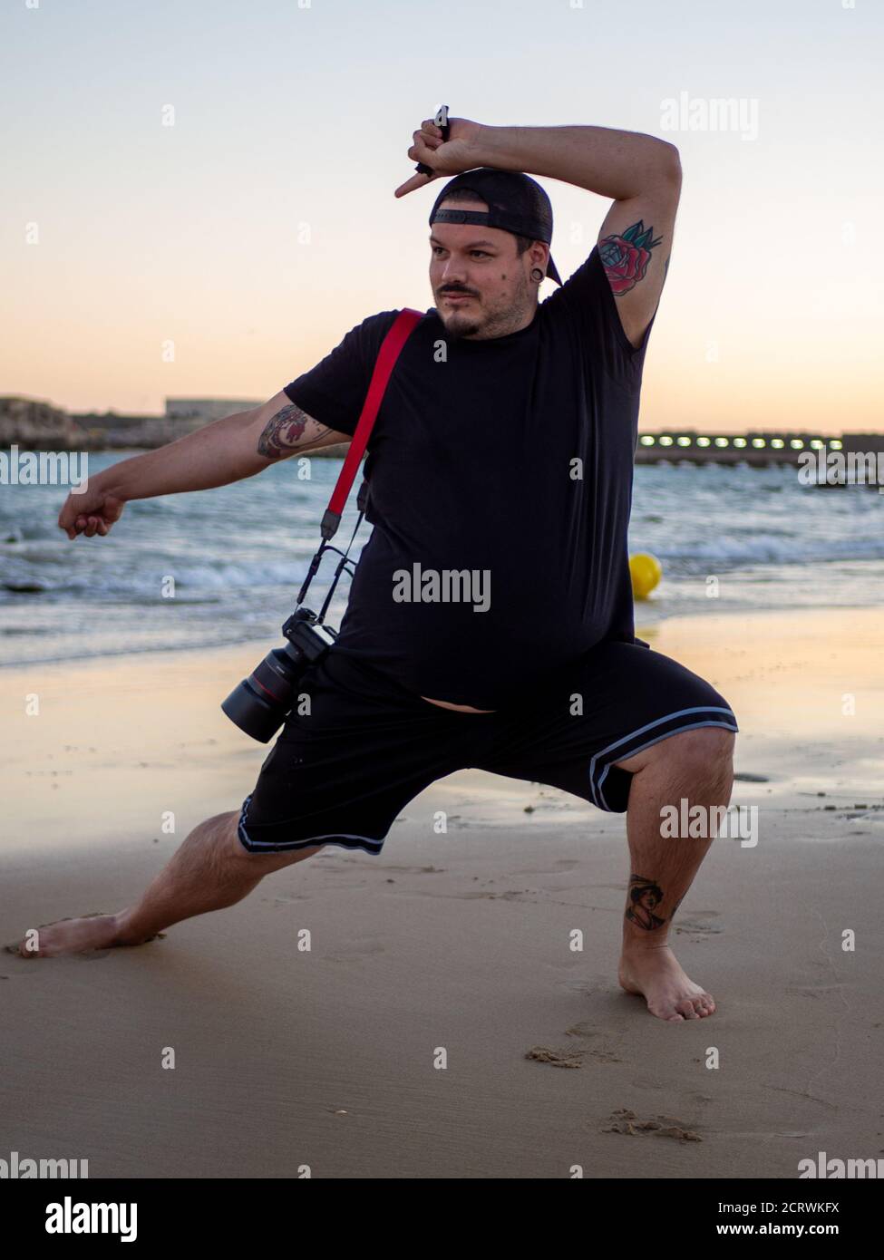 Photographer posing in the sandy beach Stock Photo - Alamy
