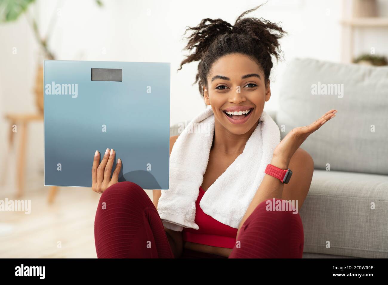 African Woman Holding Scales Sitting At Home, Smiling To Camera Stock ...