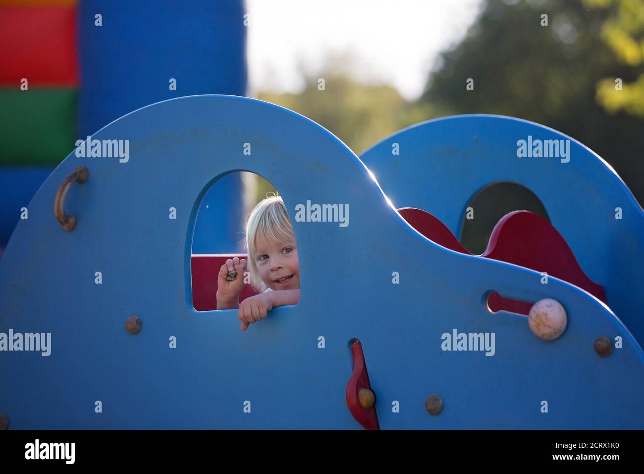 Cute child, toddler boy, playing on the playgroung on cute car toy ...