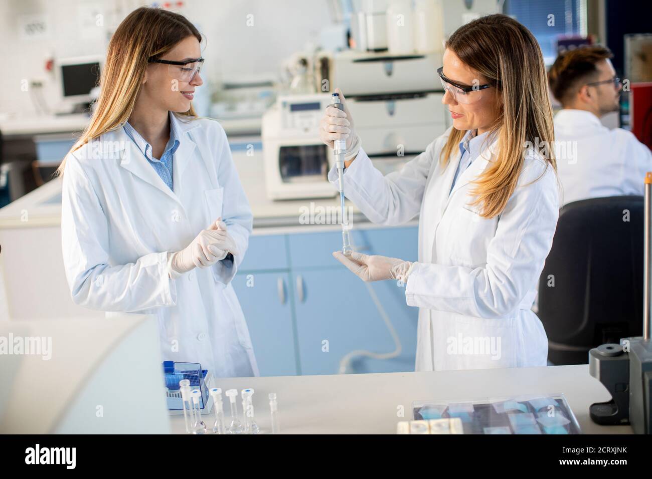 Cute female researchers in white lab coat working in the laboratory ...