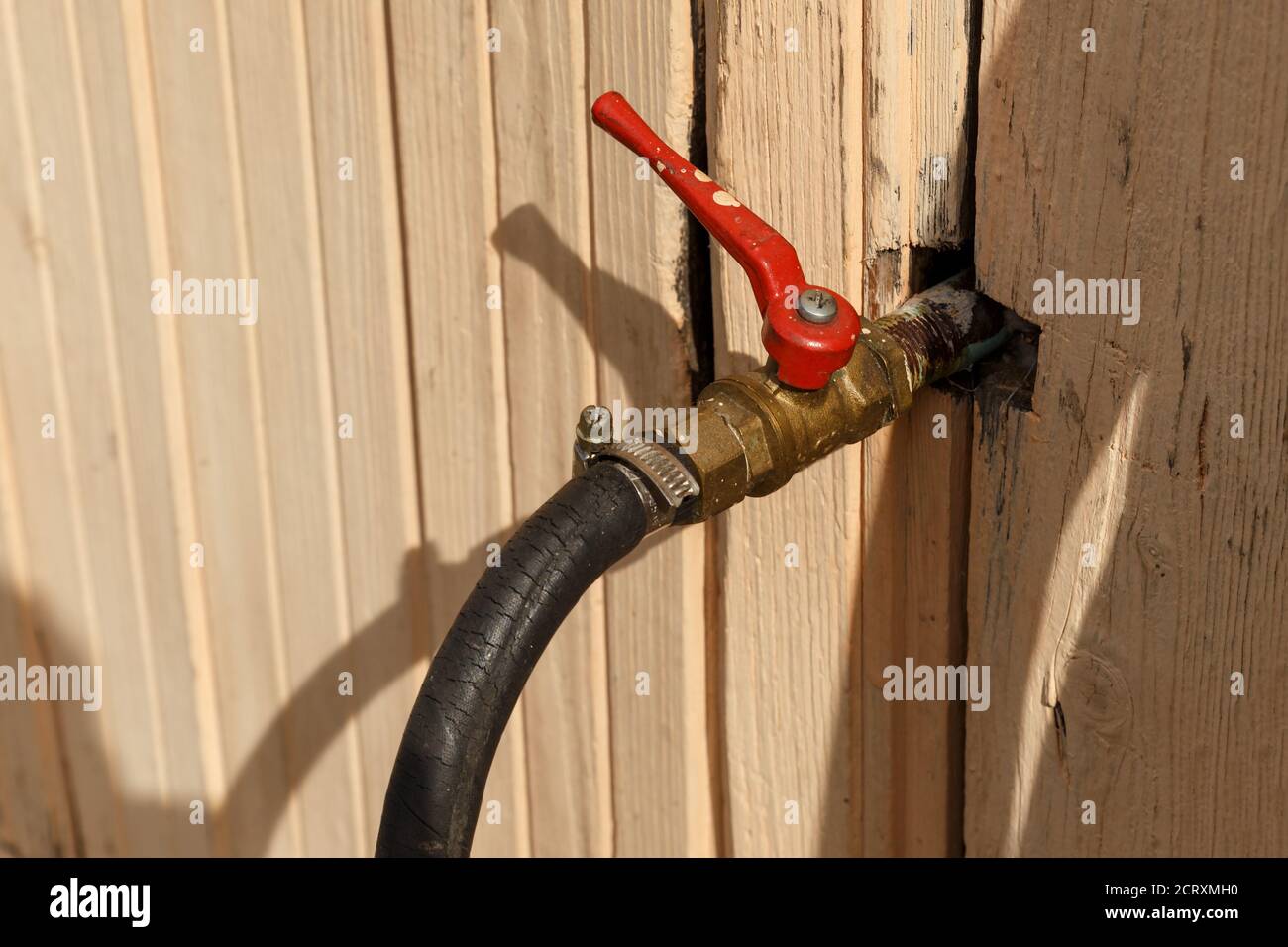 The water tap is sticking out of the wall of the house. Iron water tap ...