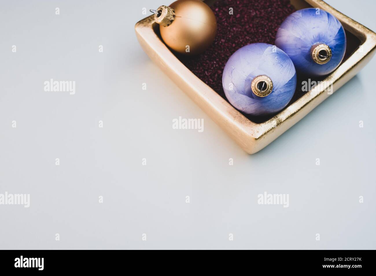 Christmas ornaments in a luxurious bowl filled with small red rocks on ...