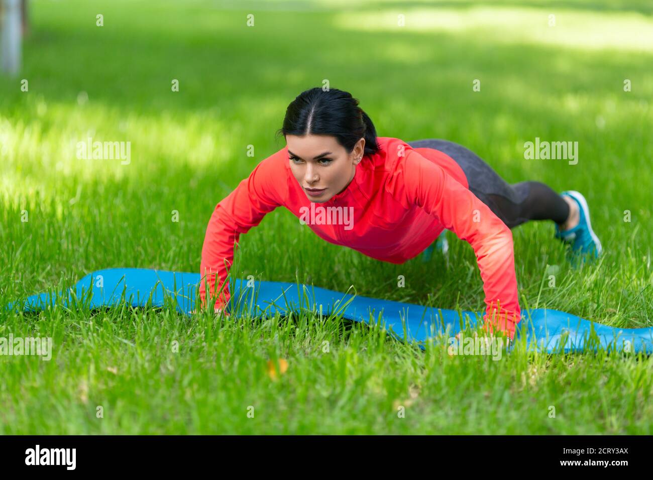 Fit woman doing a push up exercises in the park Stock Photo - Alamy