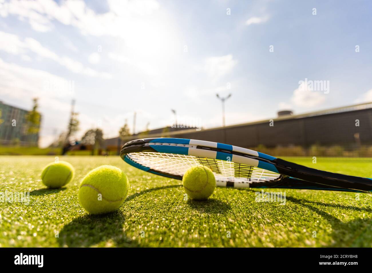 Tennis Racket on empty tennis grass court Stock Photo - Alamy