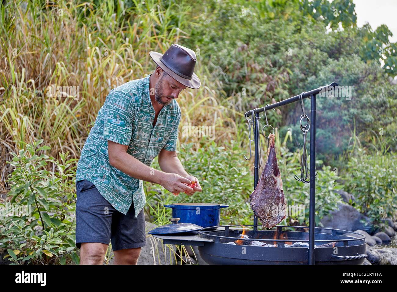 Chef Cooking over Open Flame at Campsite Along Streambed Stock Photo ...